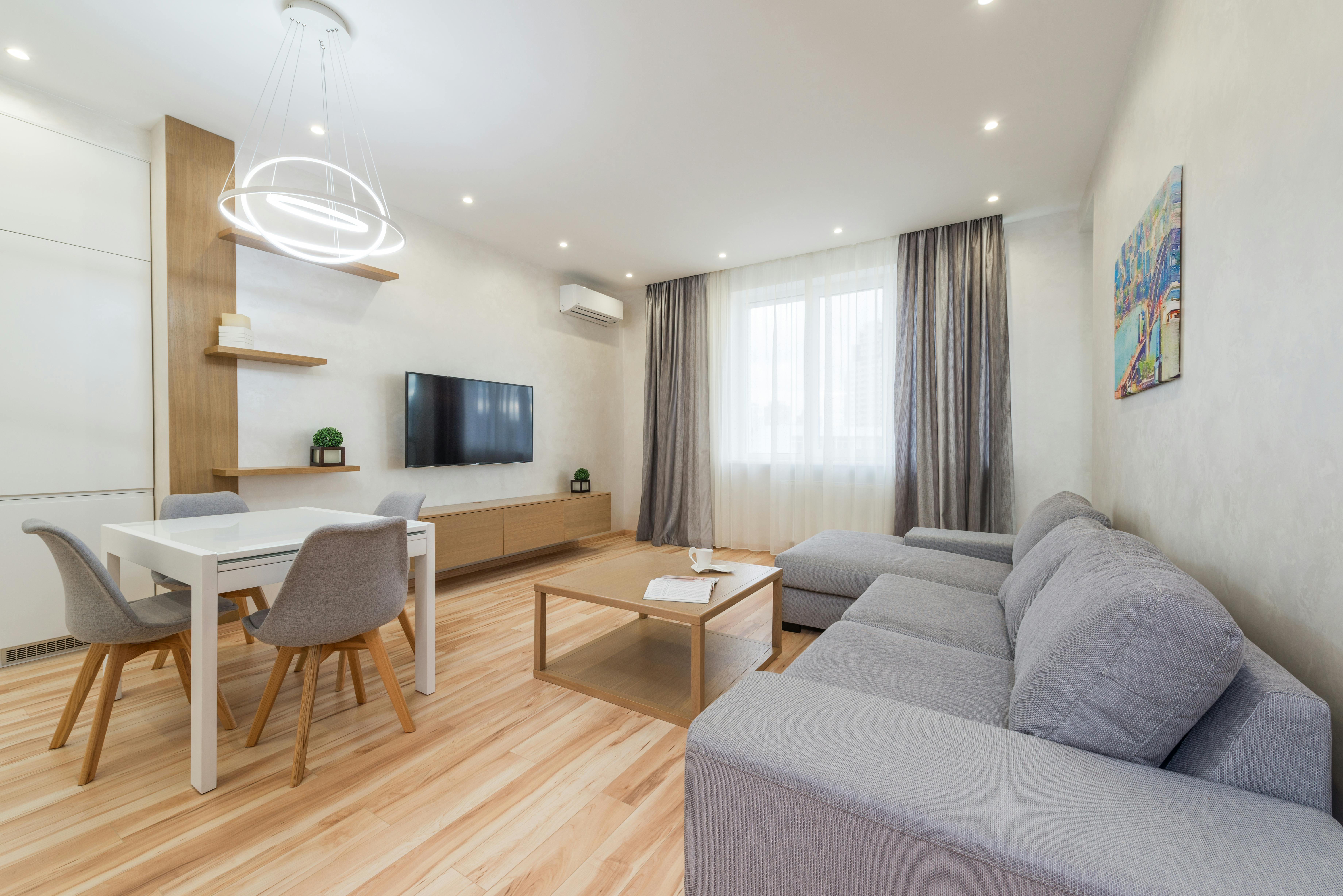 Apartment with sofa and table with chairs next to TV · Free Stock Photo