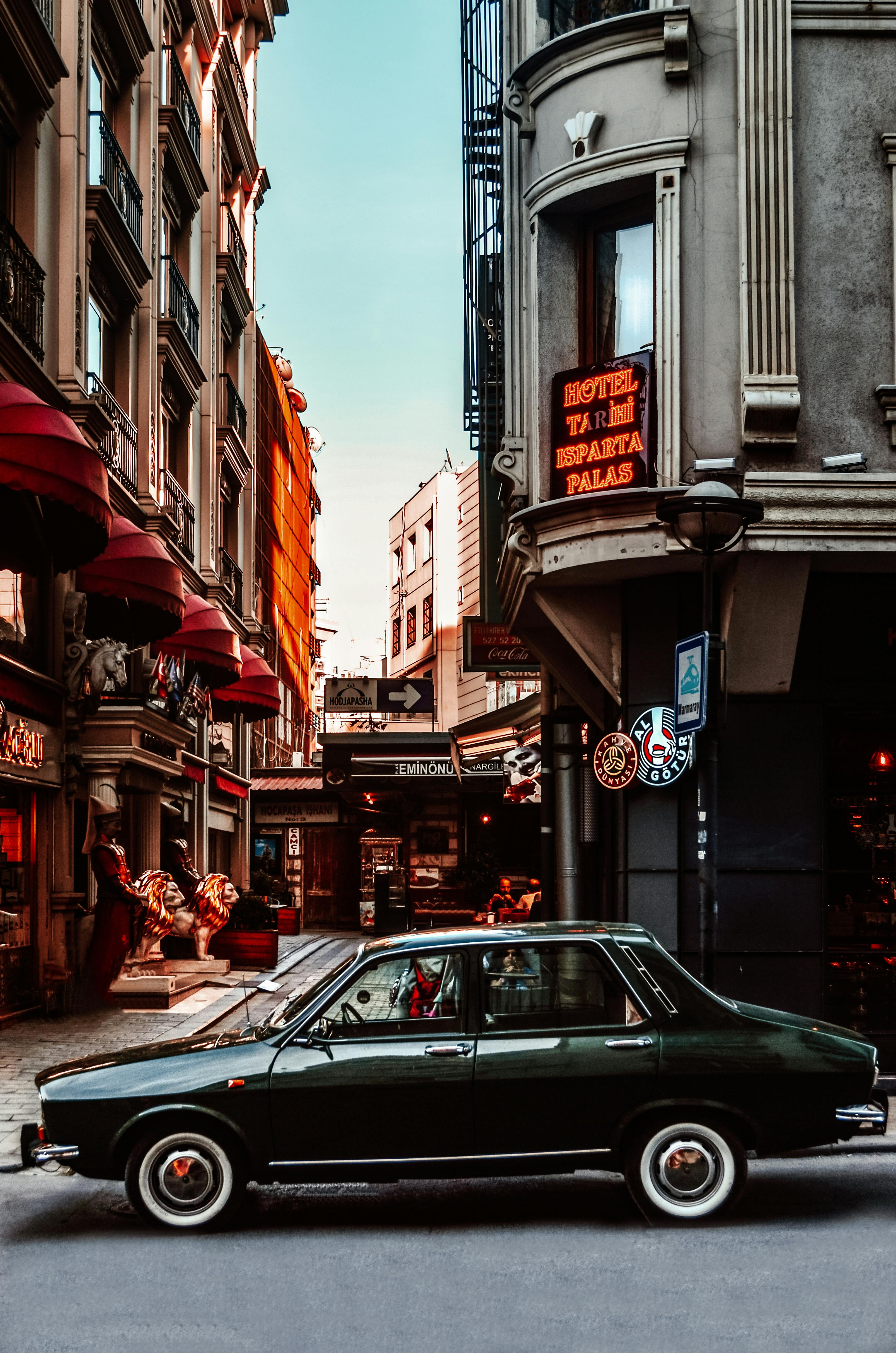 Retro car on city road against old multistory buildings · Free Stock Photo