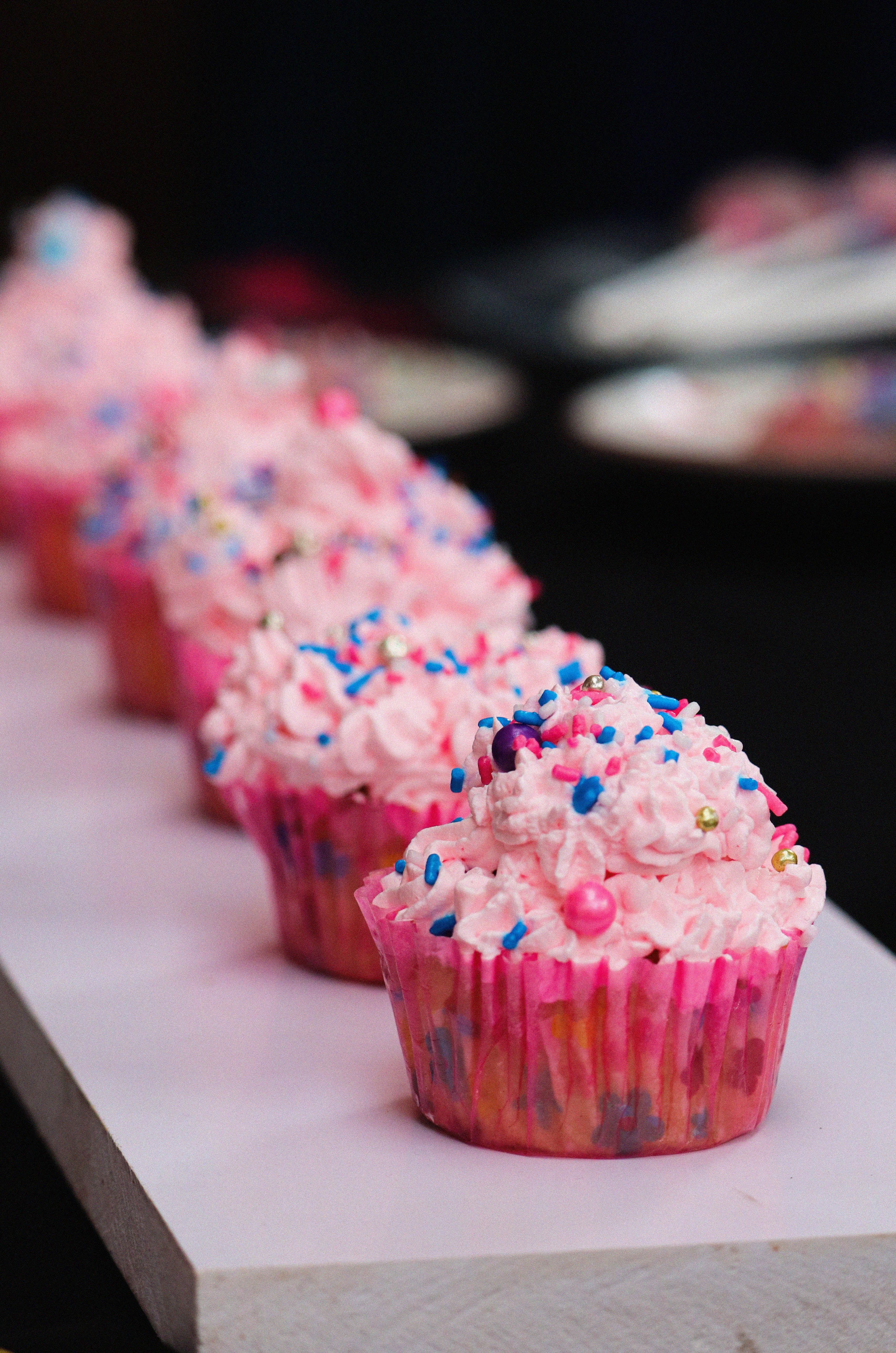 Green and Pink Cupcakes on Wooden Table · Free Stock Photo