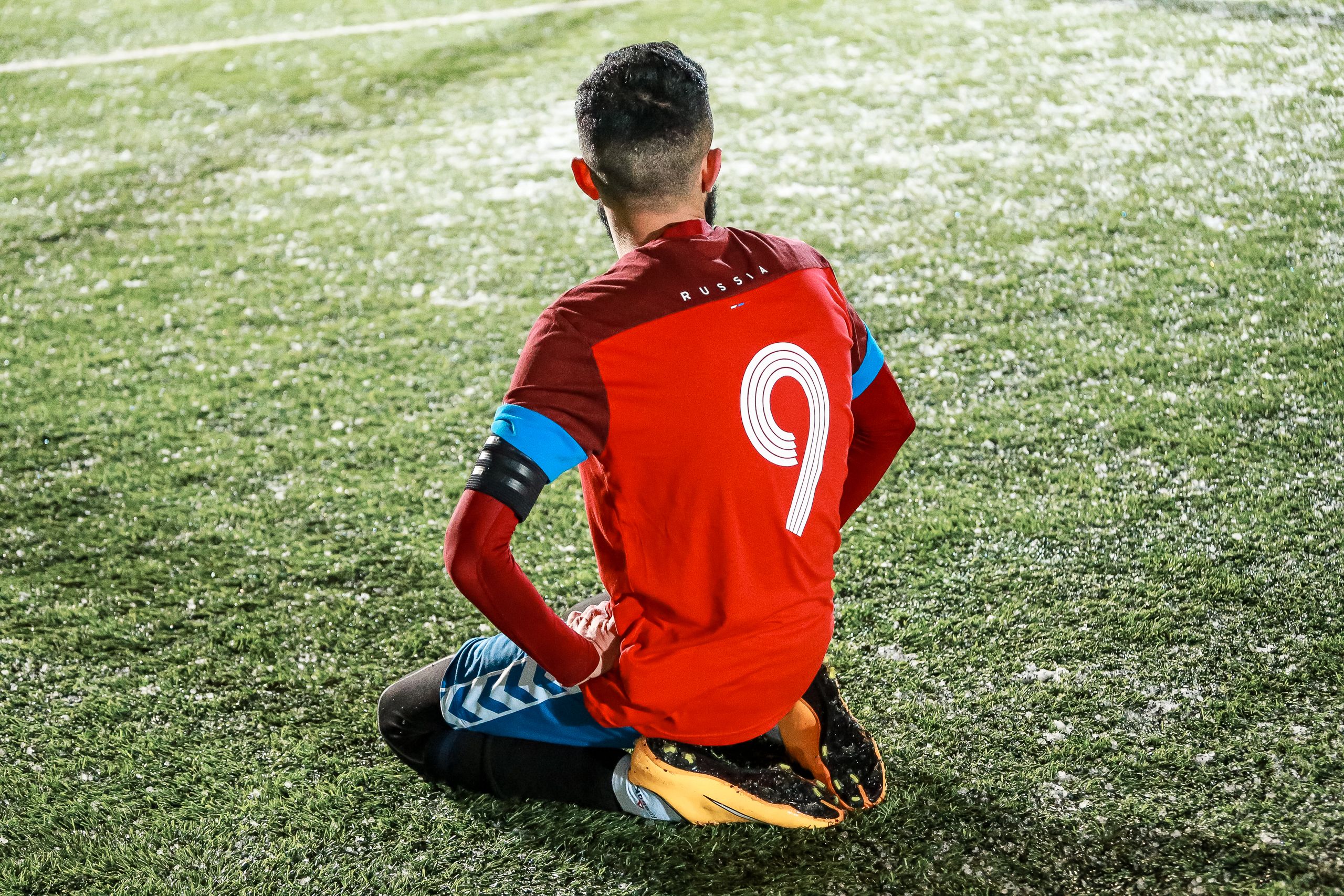 A Soccer Player Kneeling on the Grass · Free Stock Photo