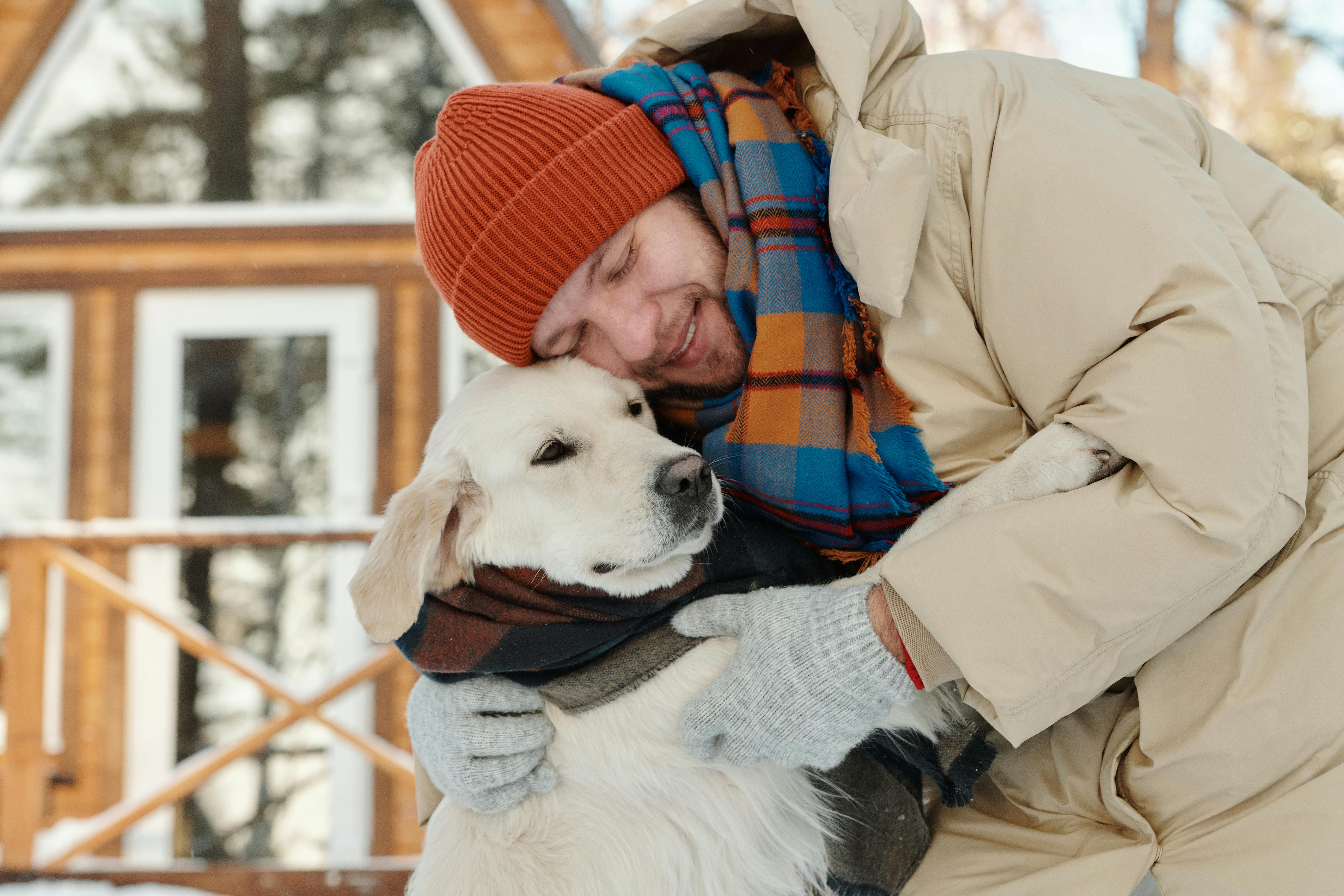 Man in Beige Jacket Hugging a White Dog · Free Stock Photo