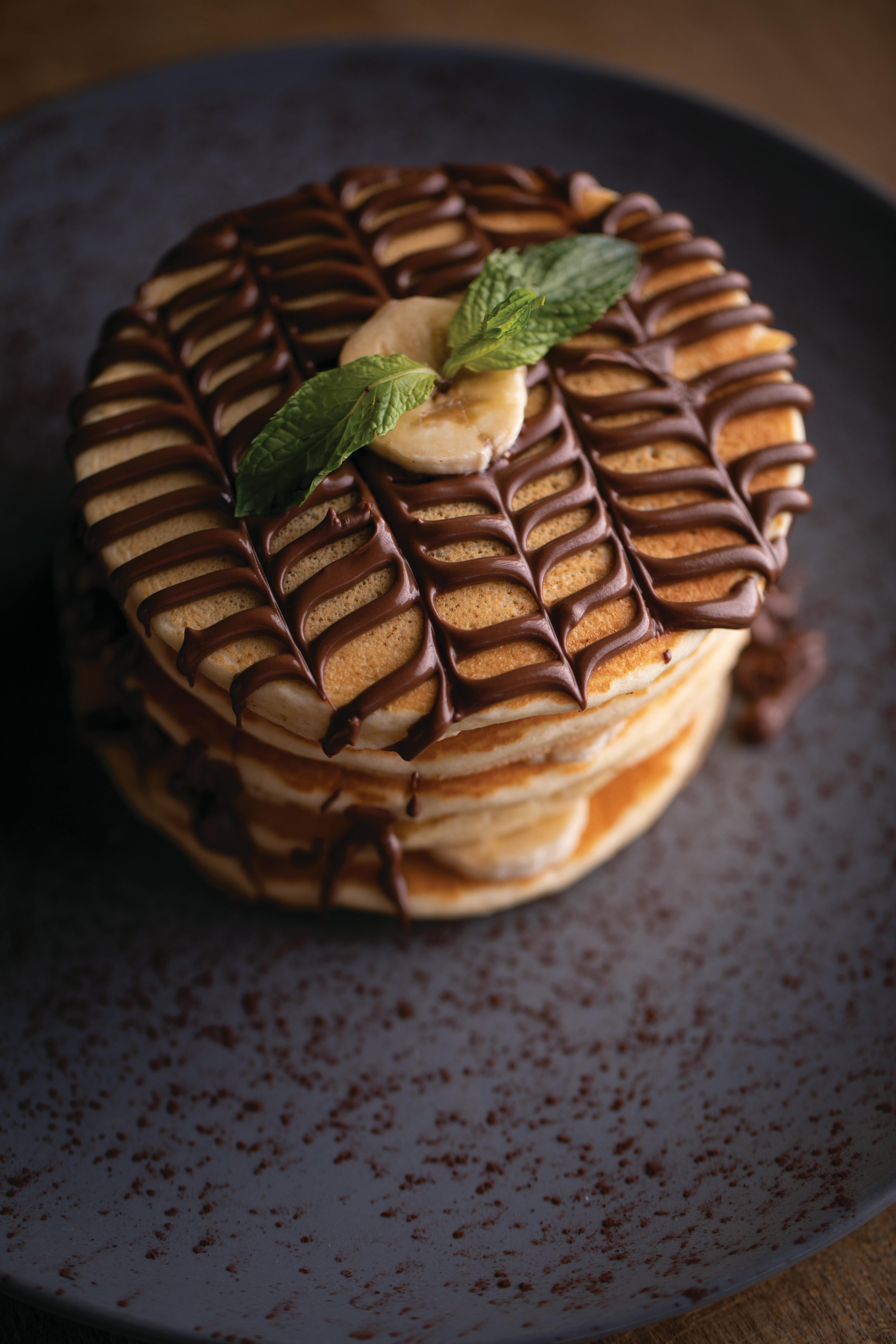 Layers of Pancakes with Chocolate Toppings on a Plate · Free Stock Photo