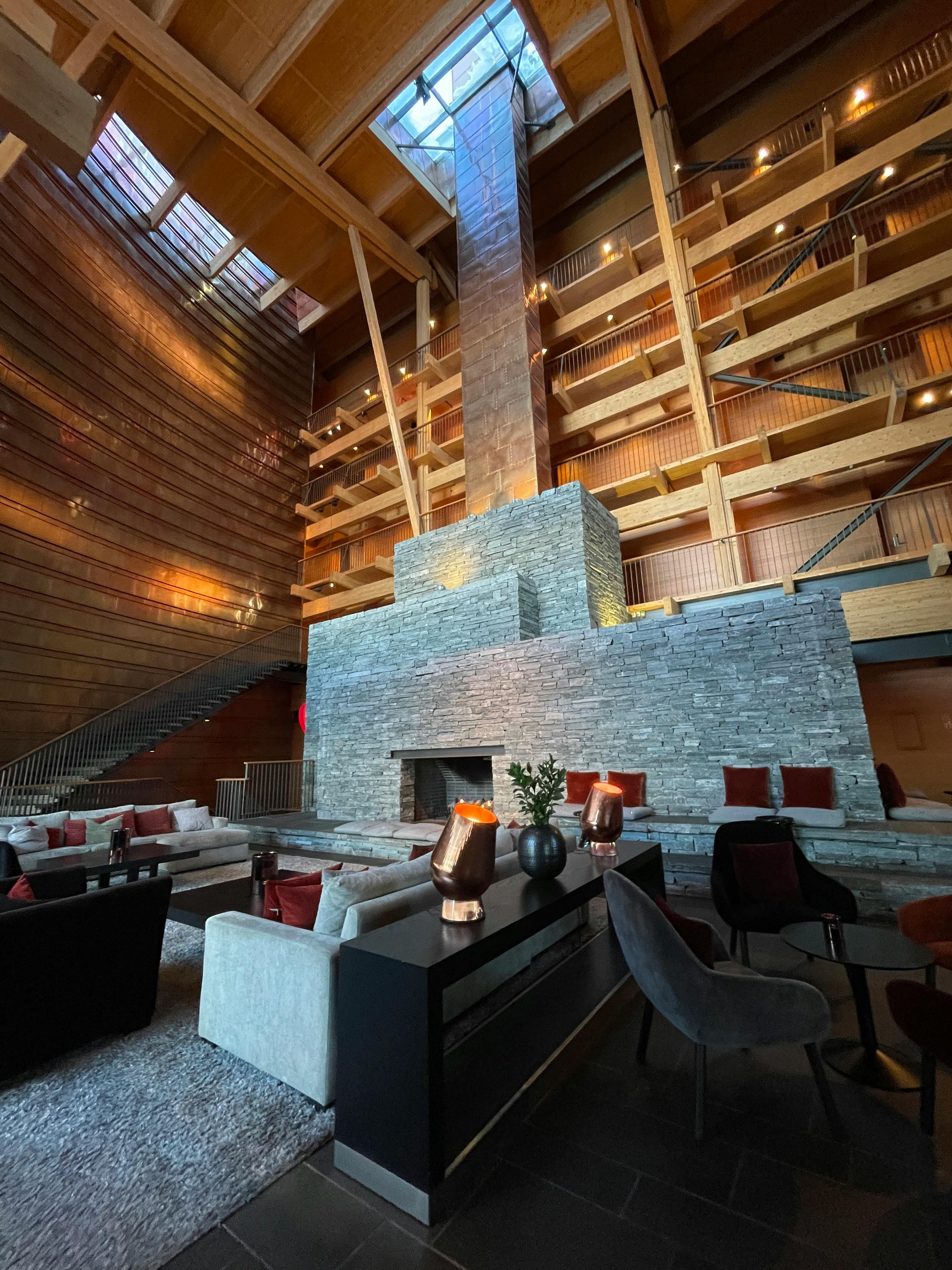 Hotel Interior With Large Fireplace in Center · Free Stock Photo