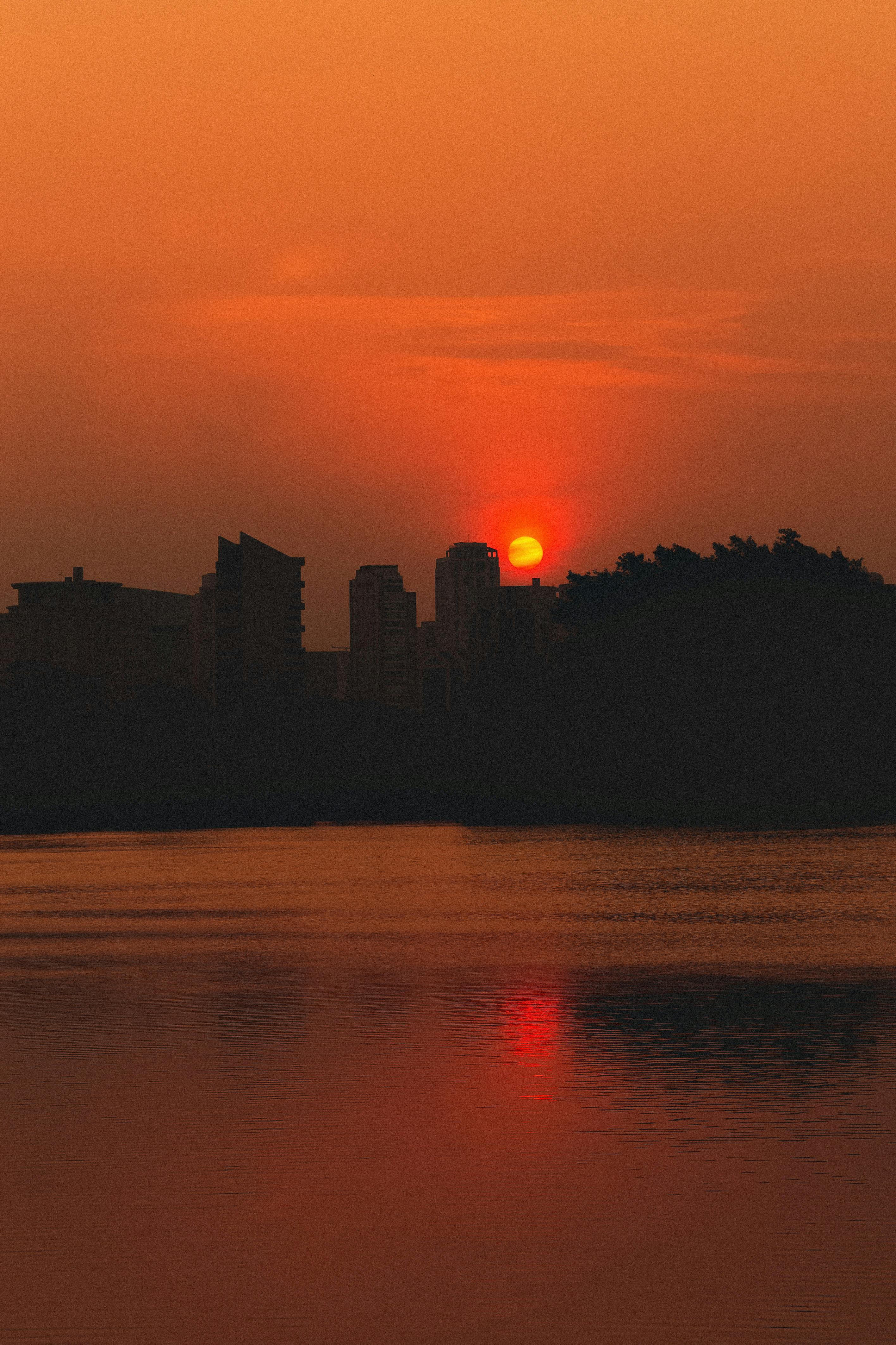 Breathtaking sunset over town with tall buildings and river · Free ...