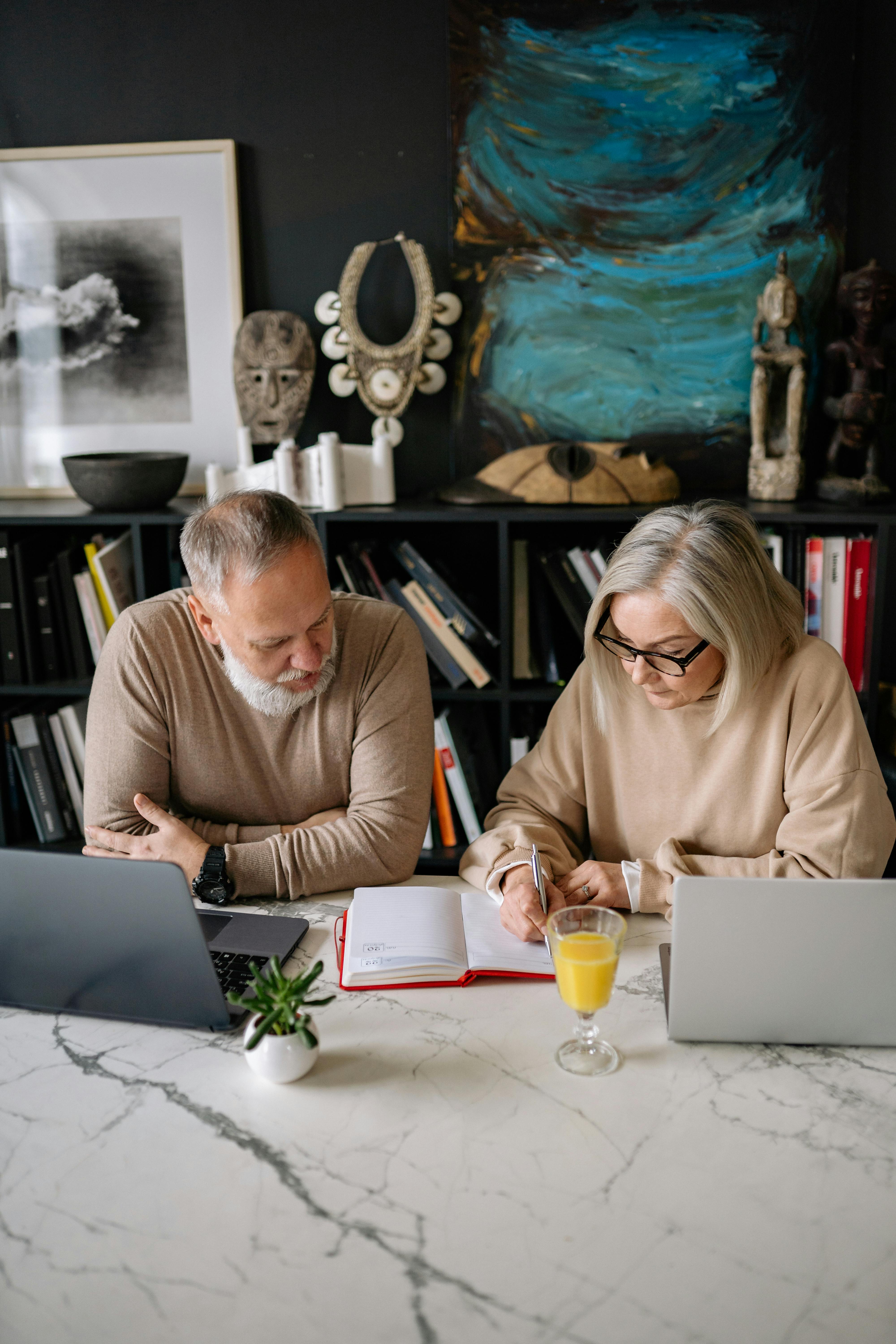 Couple Sitting on White Marbled Table with Laptops · Free Stock Photo