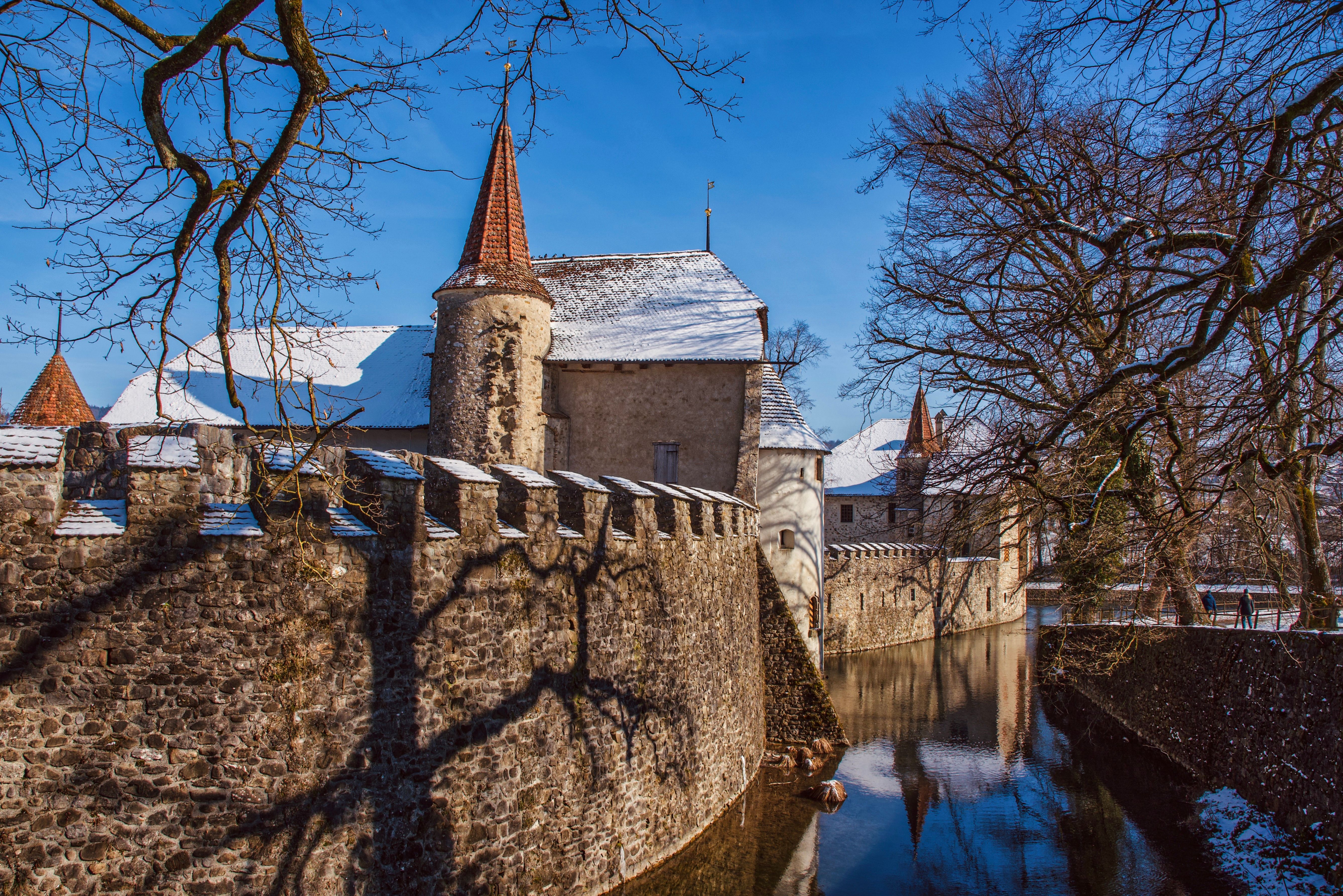 Old stone castle facade reflecting in city river · Free Stock Photo