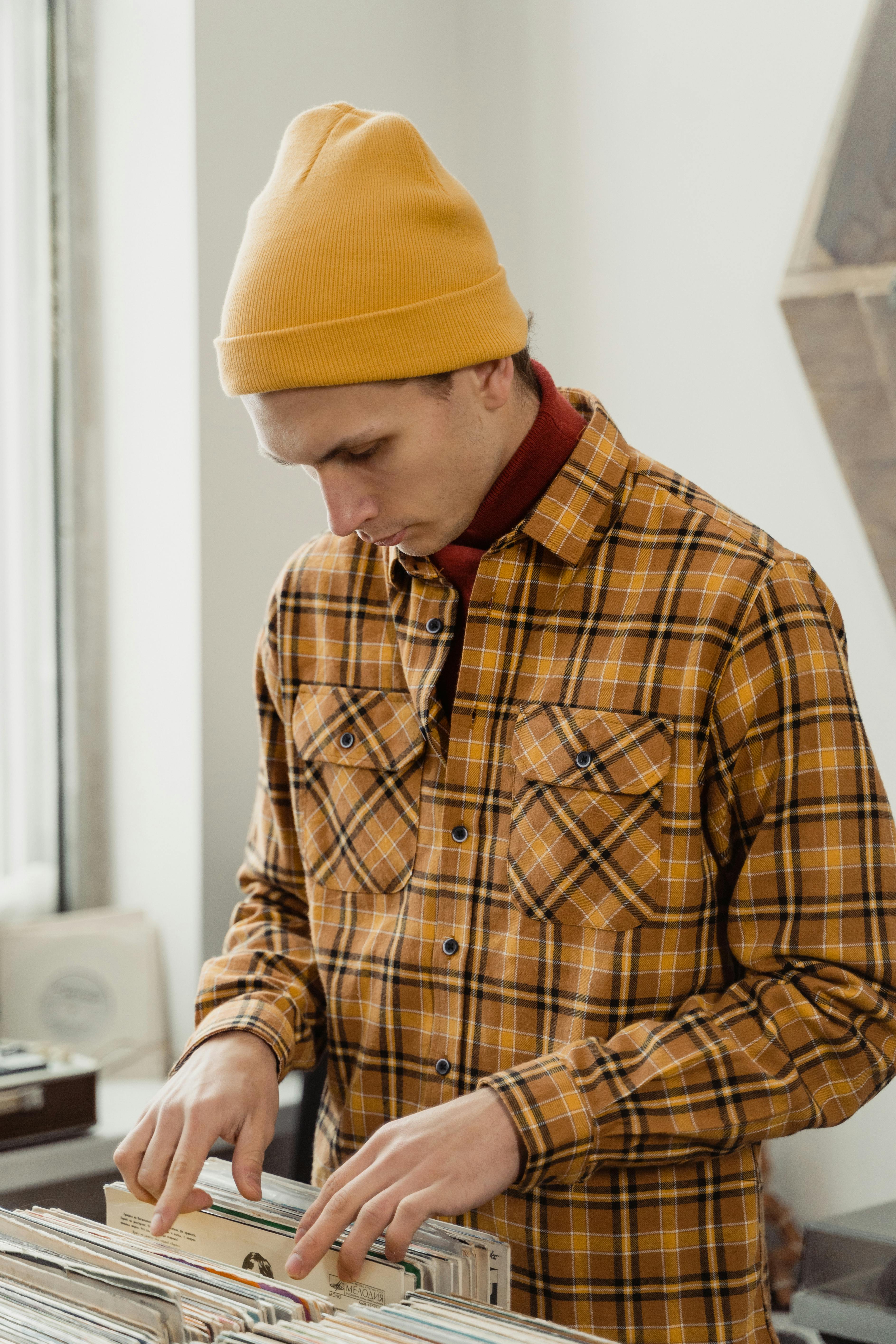 Person Wearing a Checkered Shirt in the Record store · Free Stock Photo