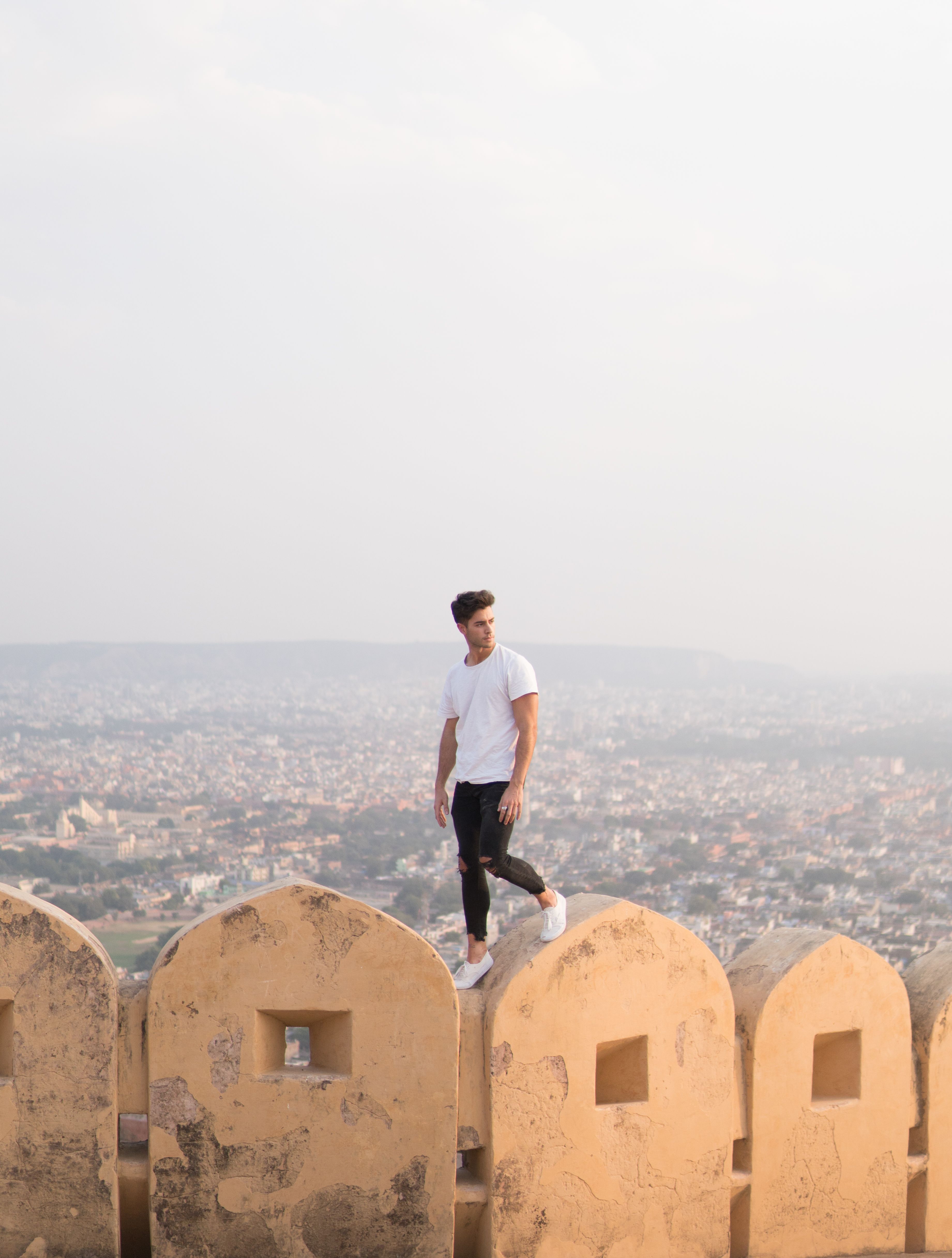 Young Man Standing on a Wall · Free Stock Photo