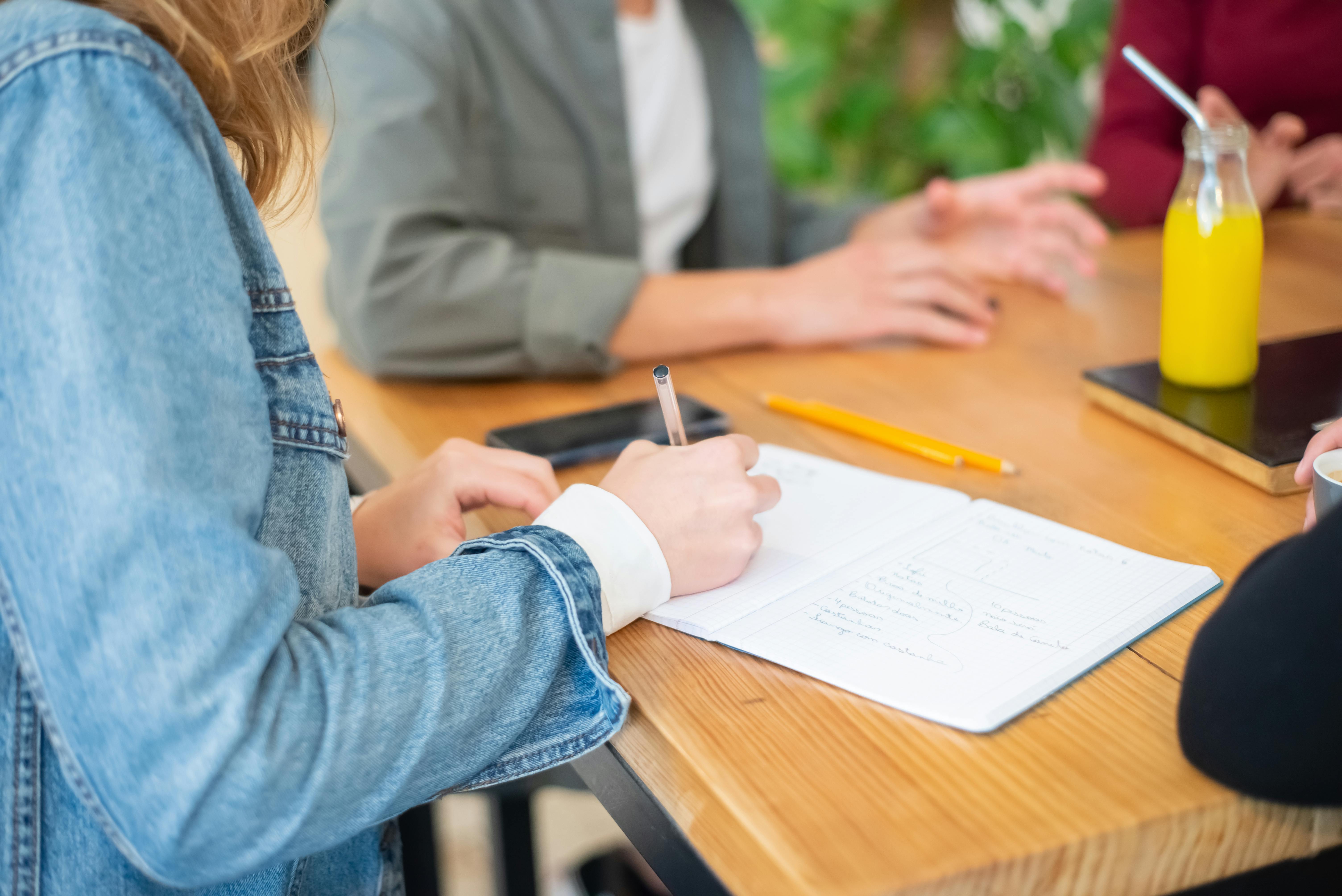 A Person Writing on a Notebook · Free Stock Photo