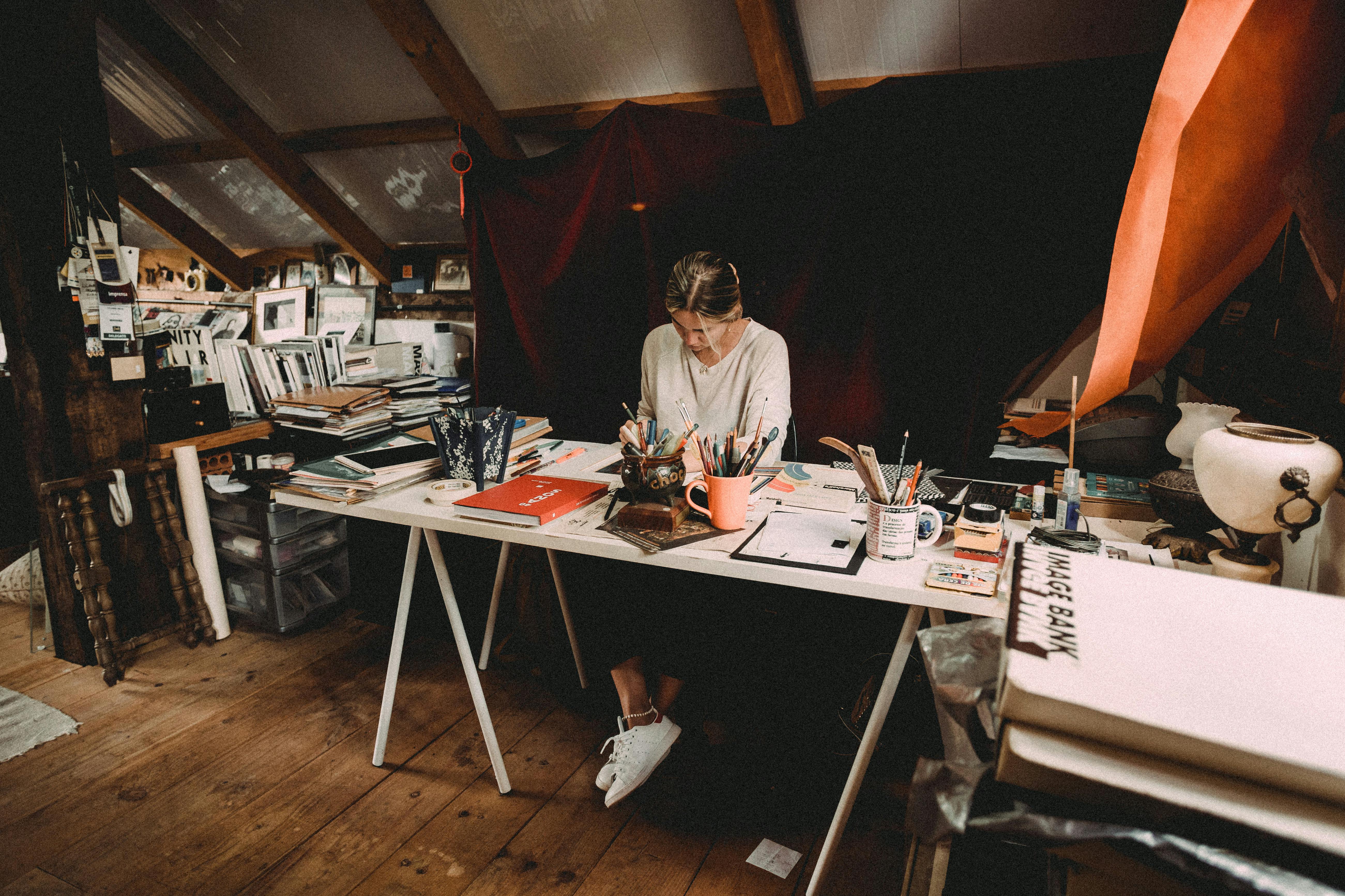 Woman drawing at table with different pencils · Free Stock Photo