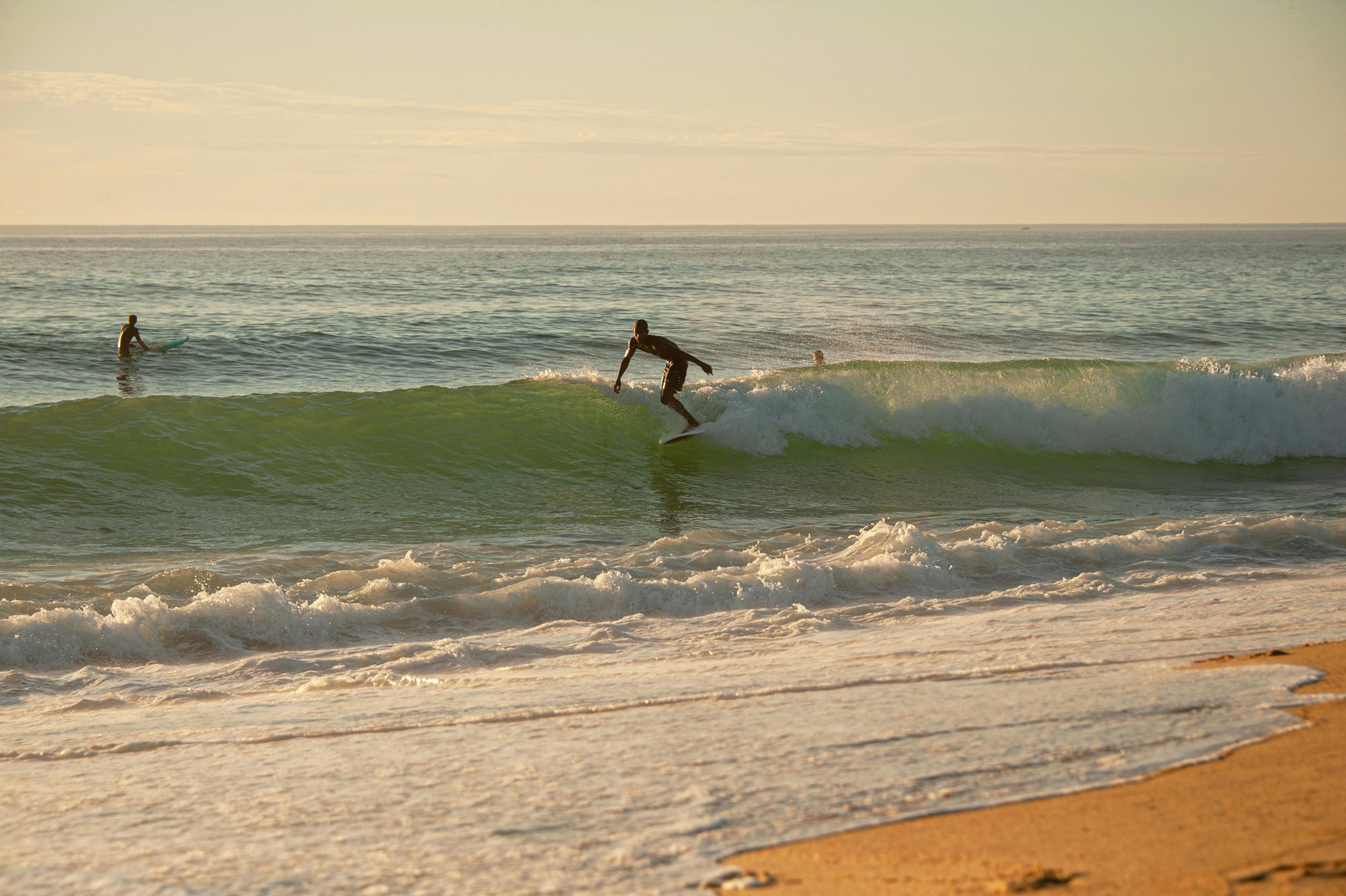 Photo of a Man Surfing at the Beach · Free Stock Photo