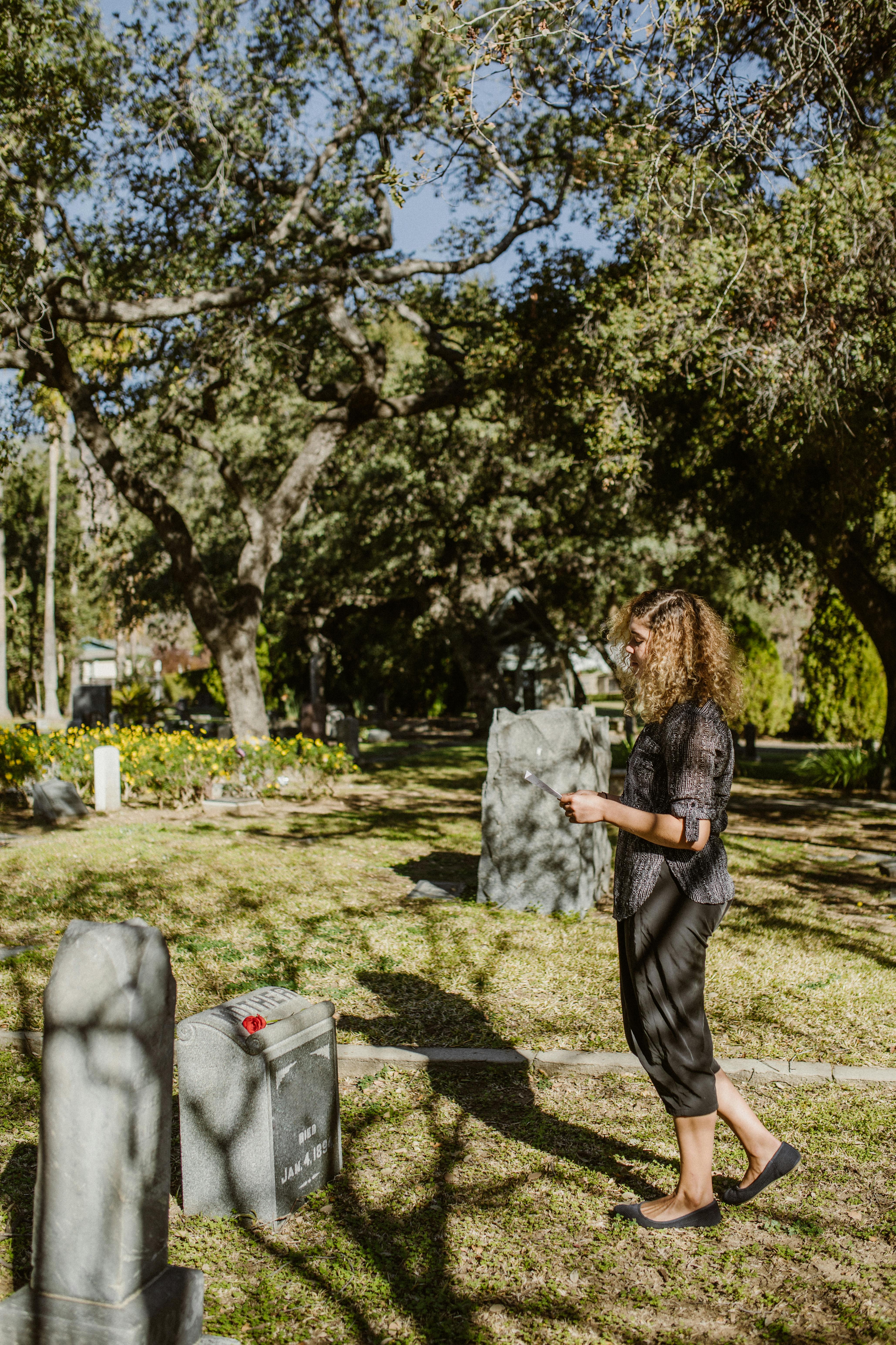 A Man Smoking a Cigarette while Sitting on a Grave · Free Stock Photo