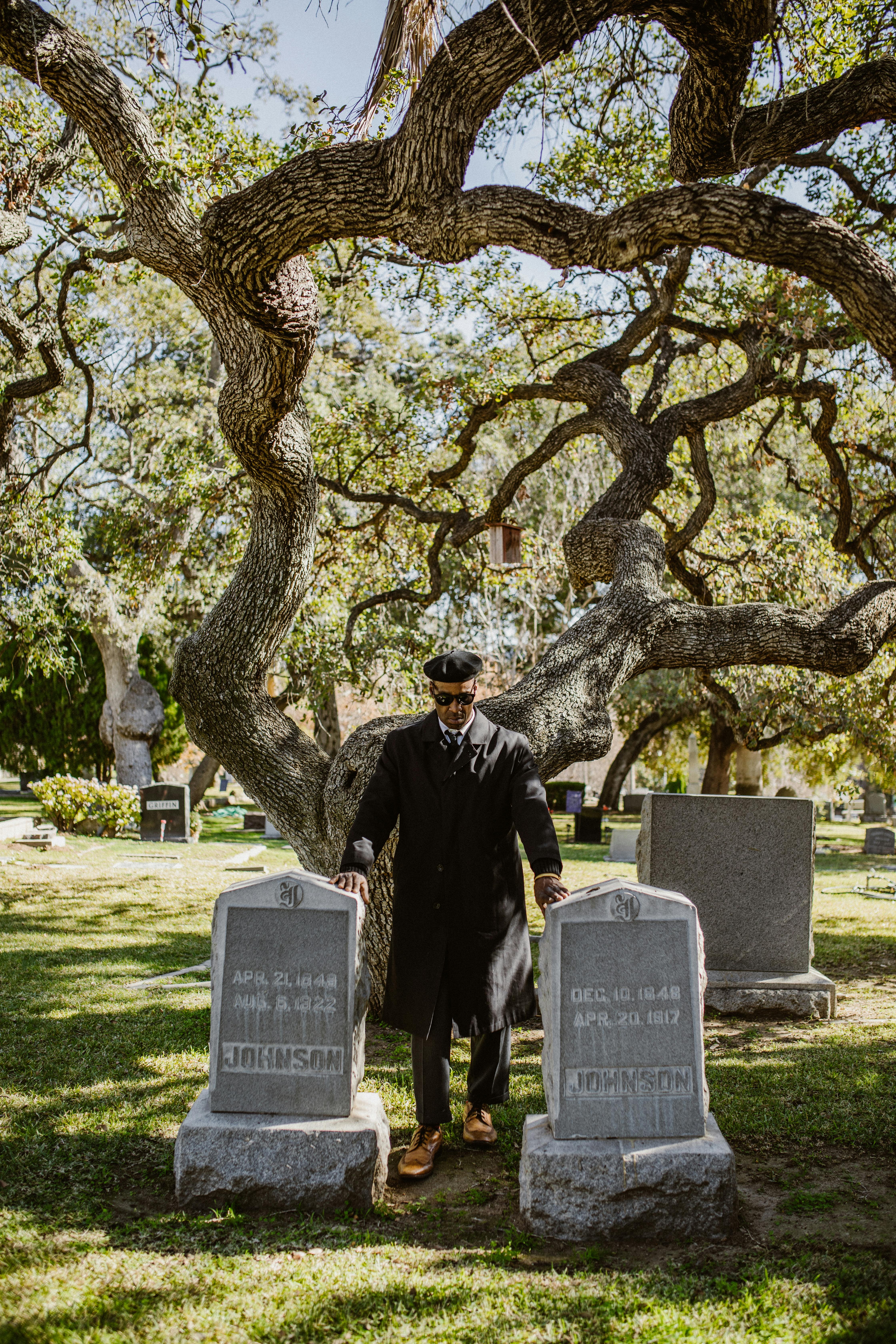Person Standing in Front Of A Gravestone With Red Flowers · Free Stock ...