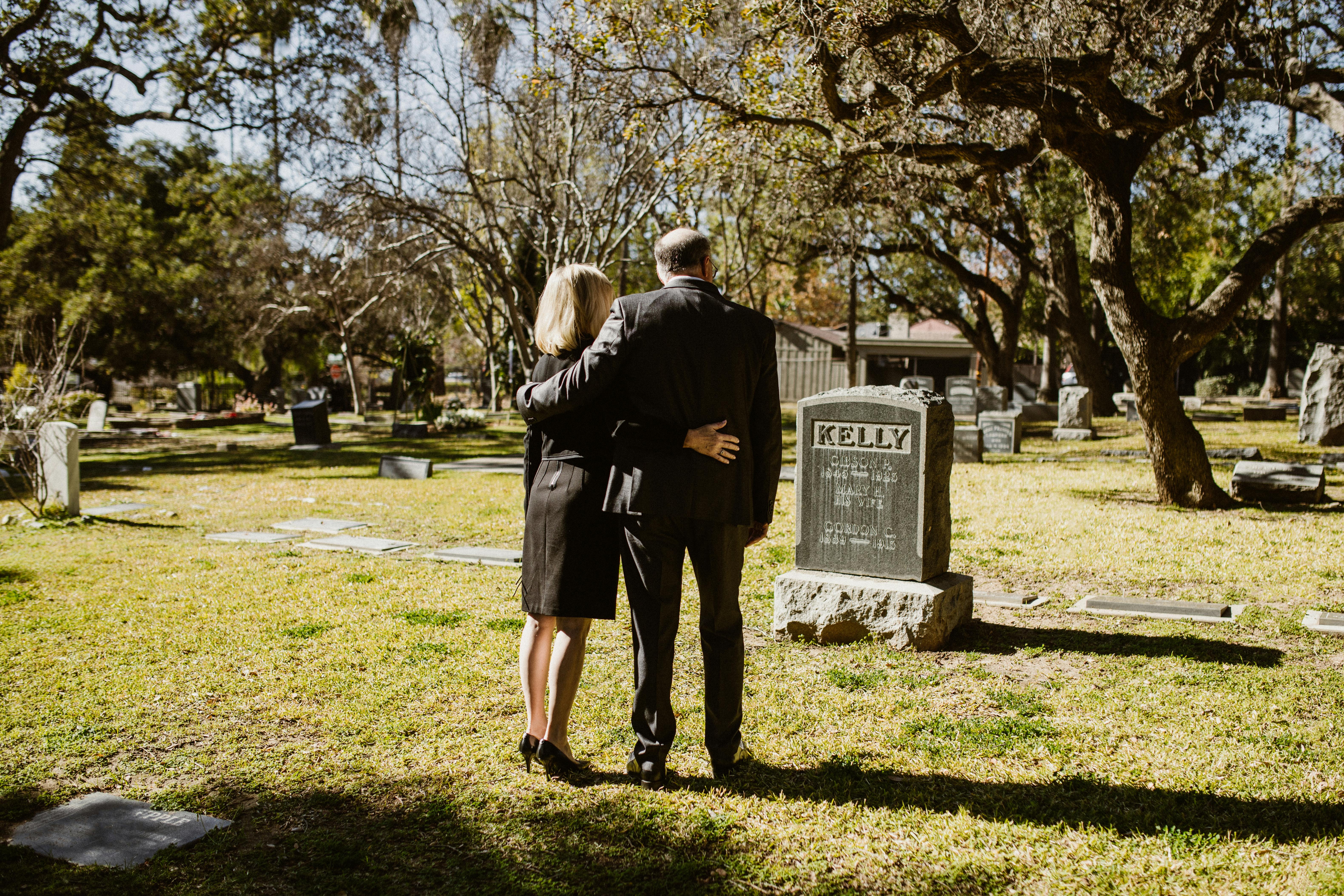 A Couple Standing In Front of a Tombstone · Free Stock Photo