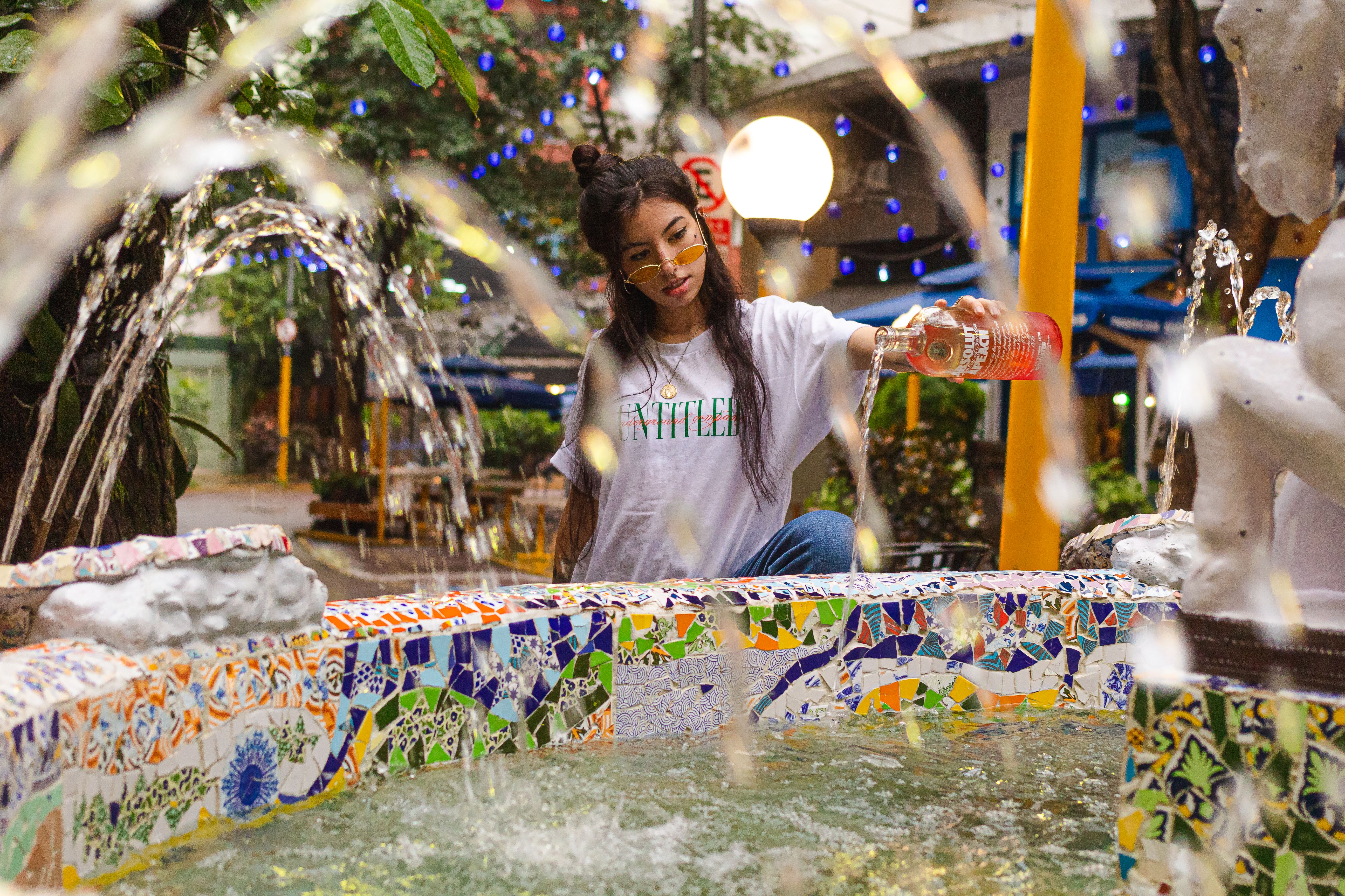 Stylish woman pouring vodka into fountain · Free Stock Photo