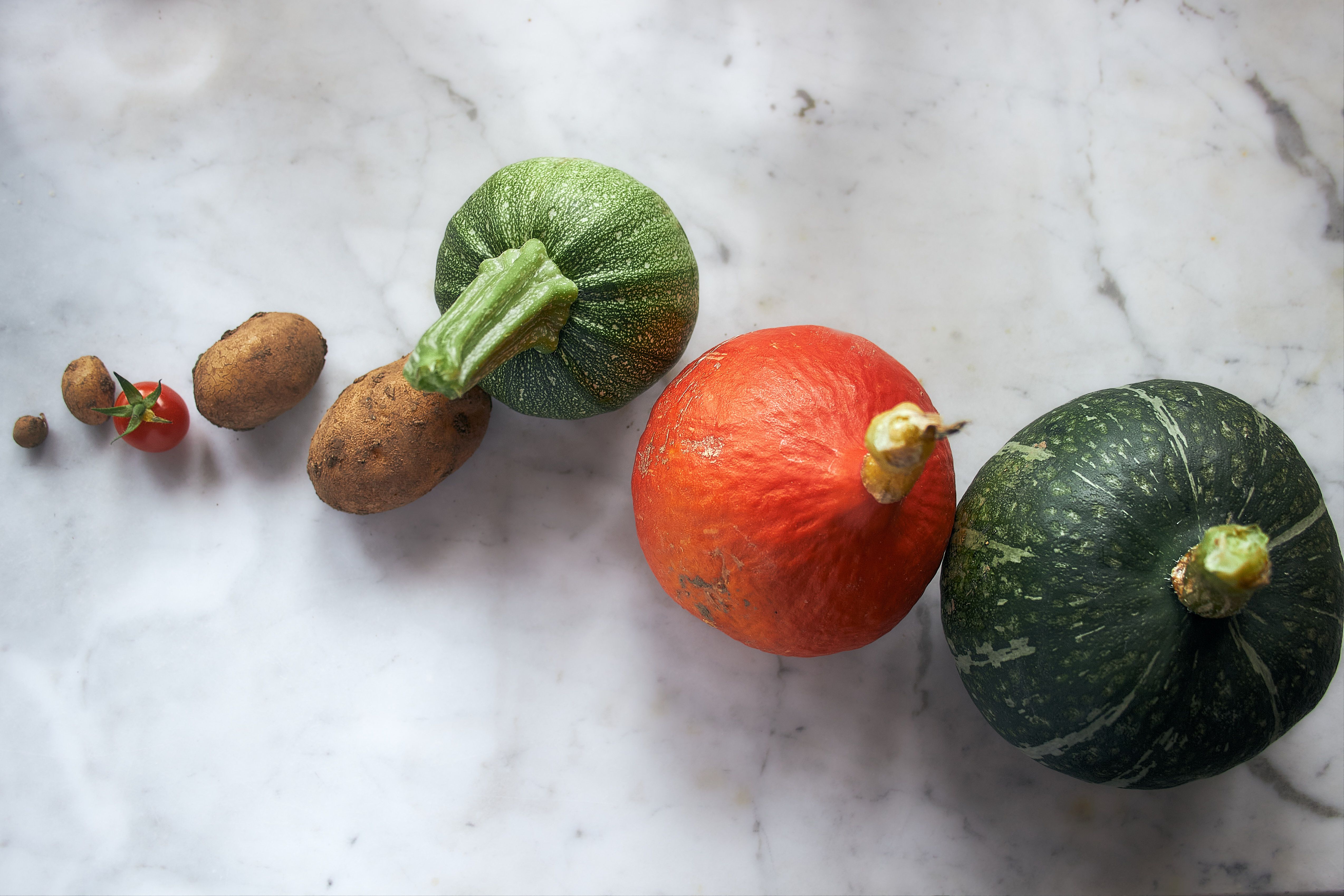 Gourds on White Surface with Potatoes and Tomato · Free Stock Photo