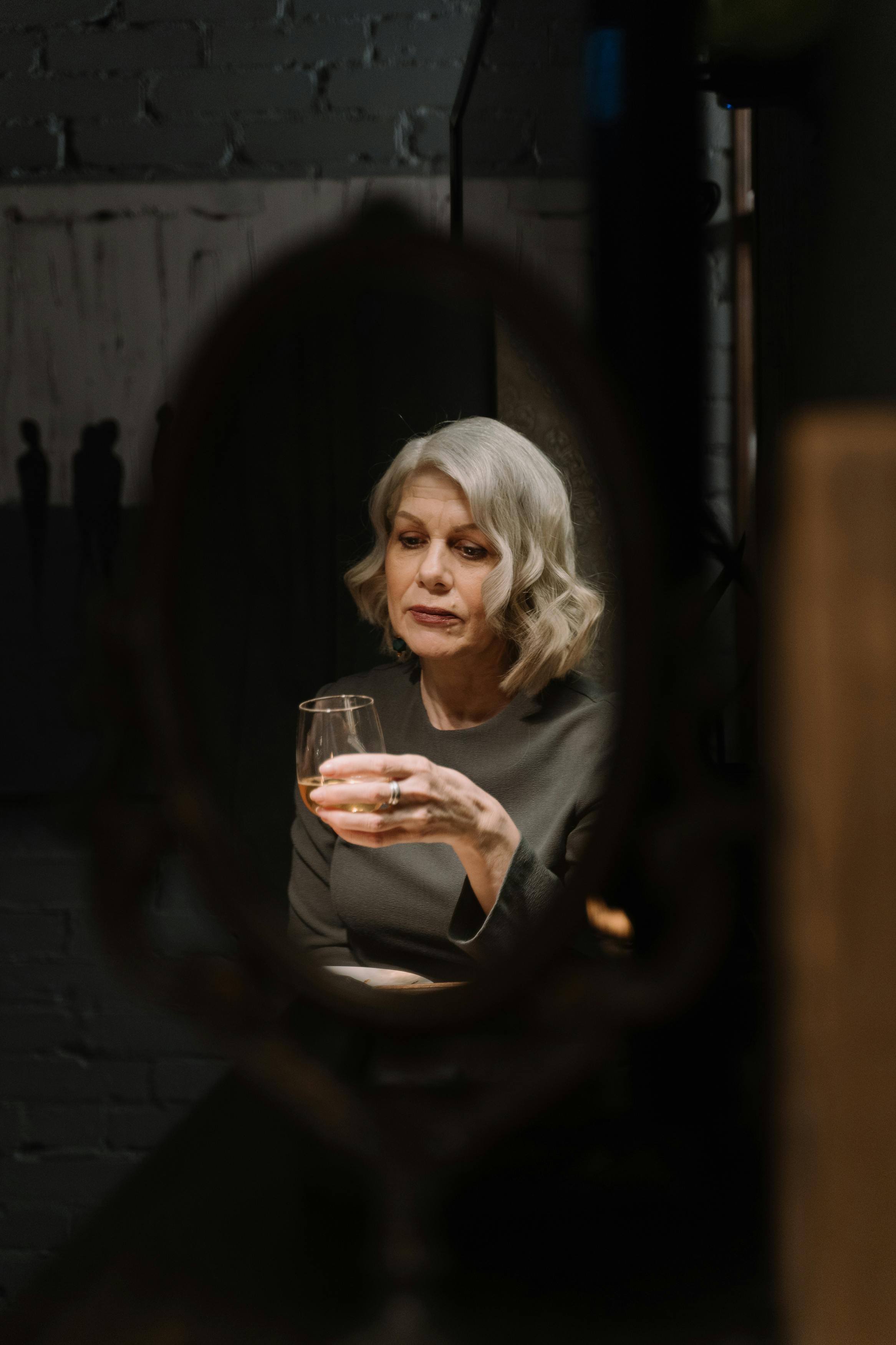 Woman Looking at her Grey Hairs in Mirror · Free Stock Photo