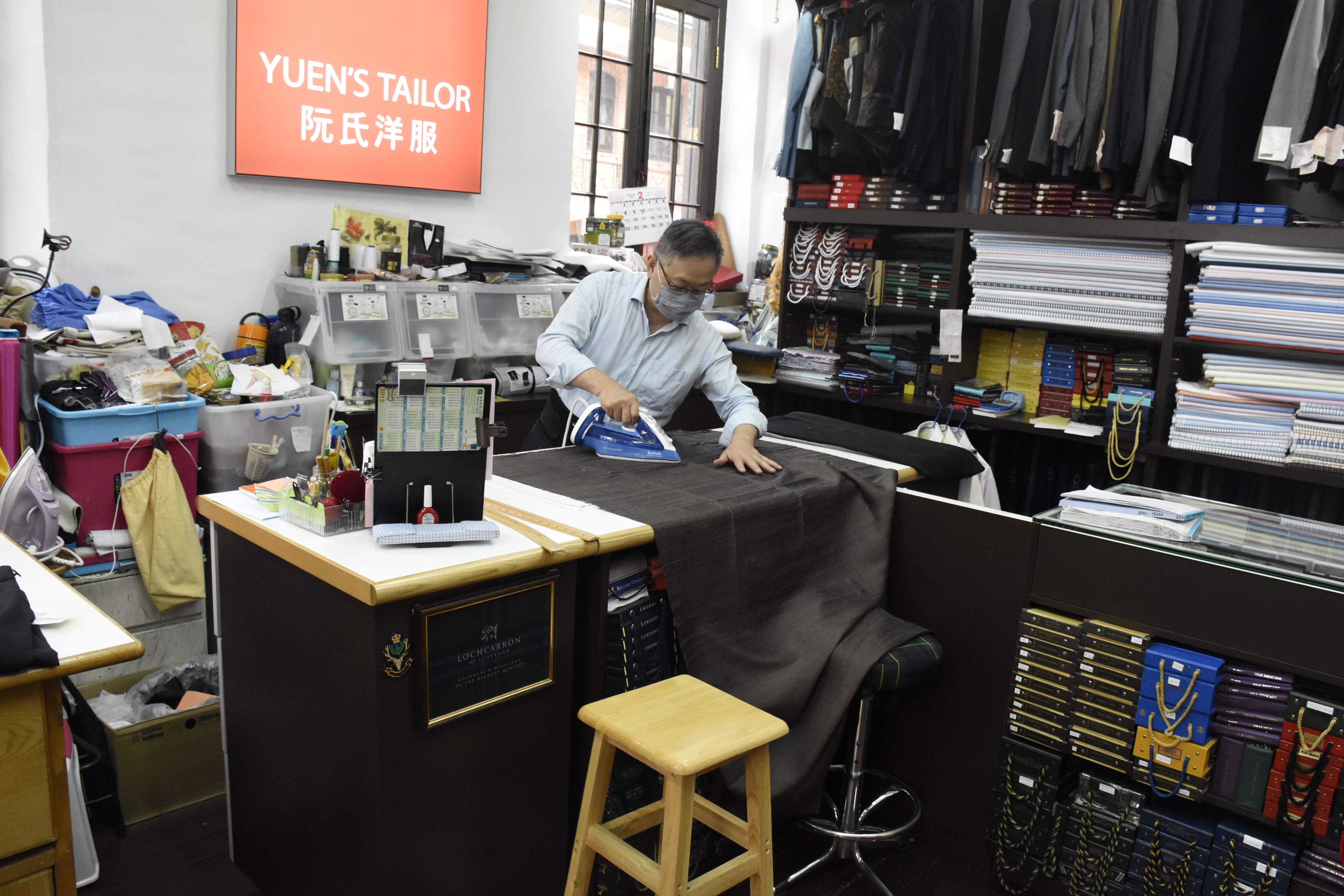 Man Wearing a Face Mask Ironing the Fabric · Free Stock Photo