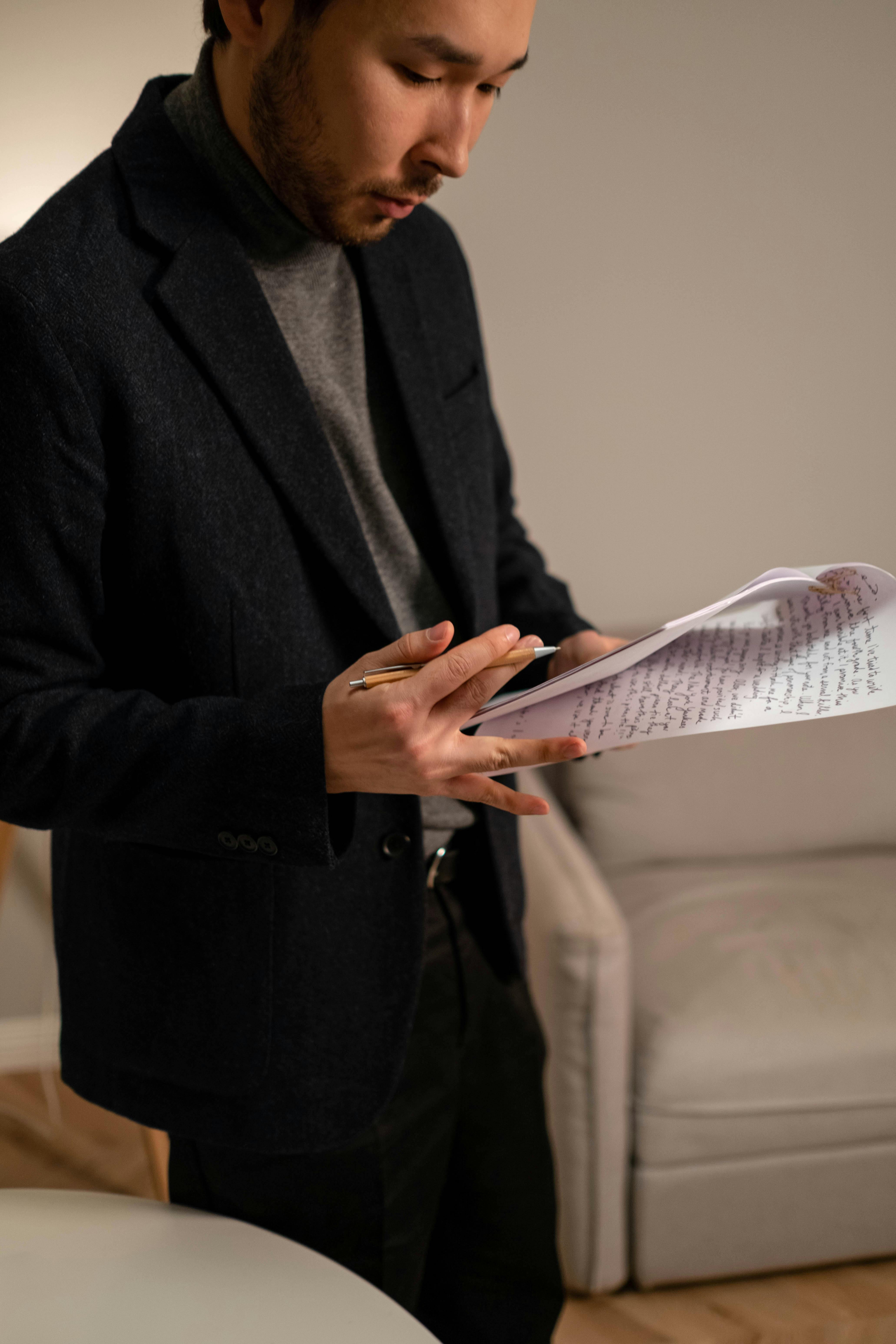 A Man in Black Suit Holding Documents · Free Stock Photo