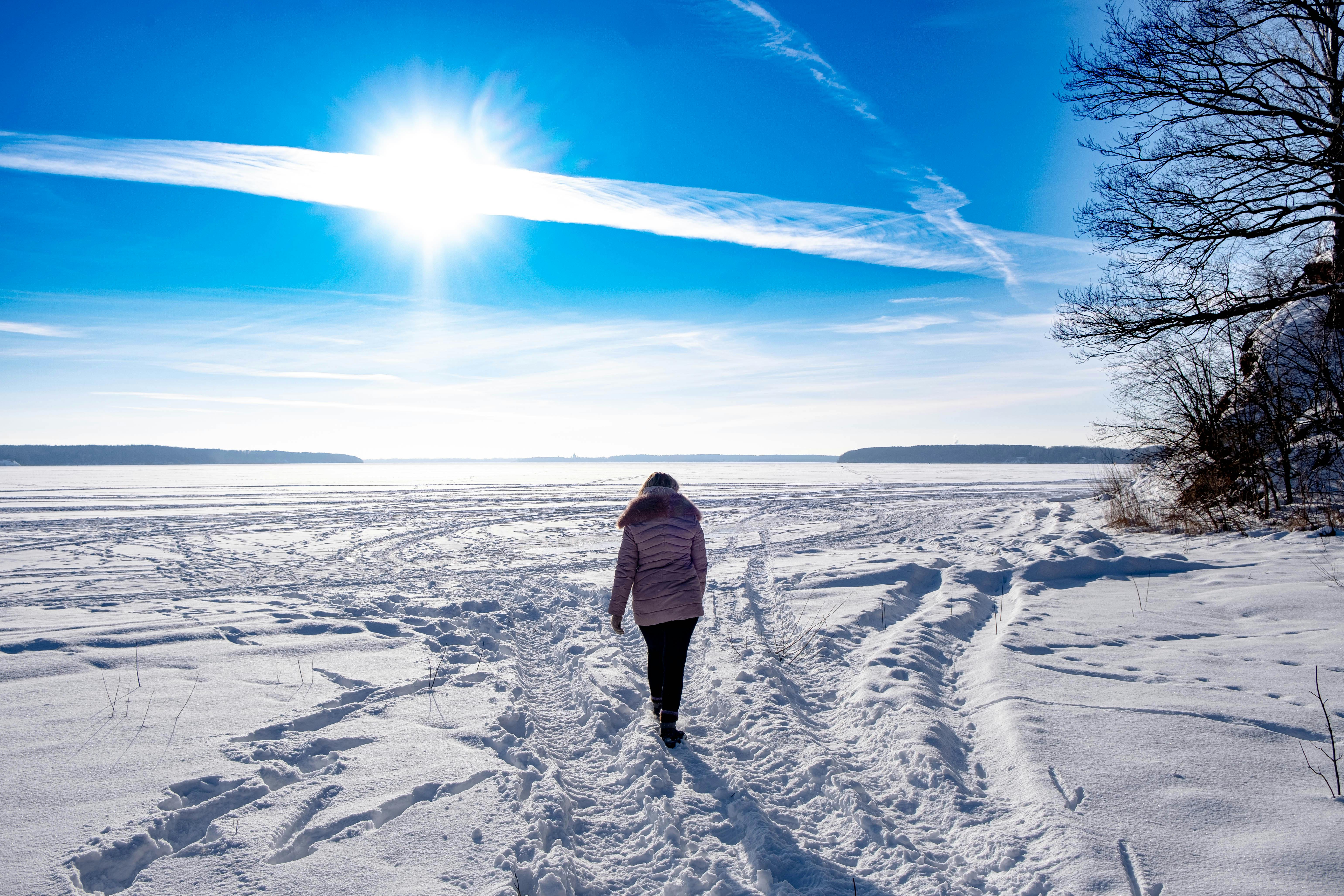 Person Walking on Snow Covered Field · Free Stock Photo