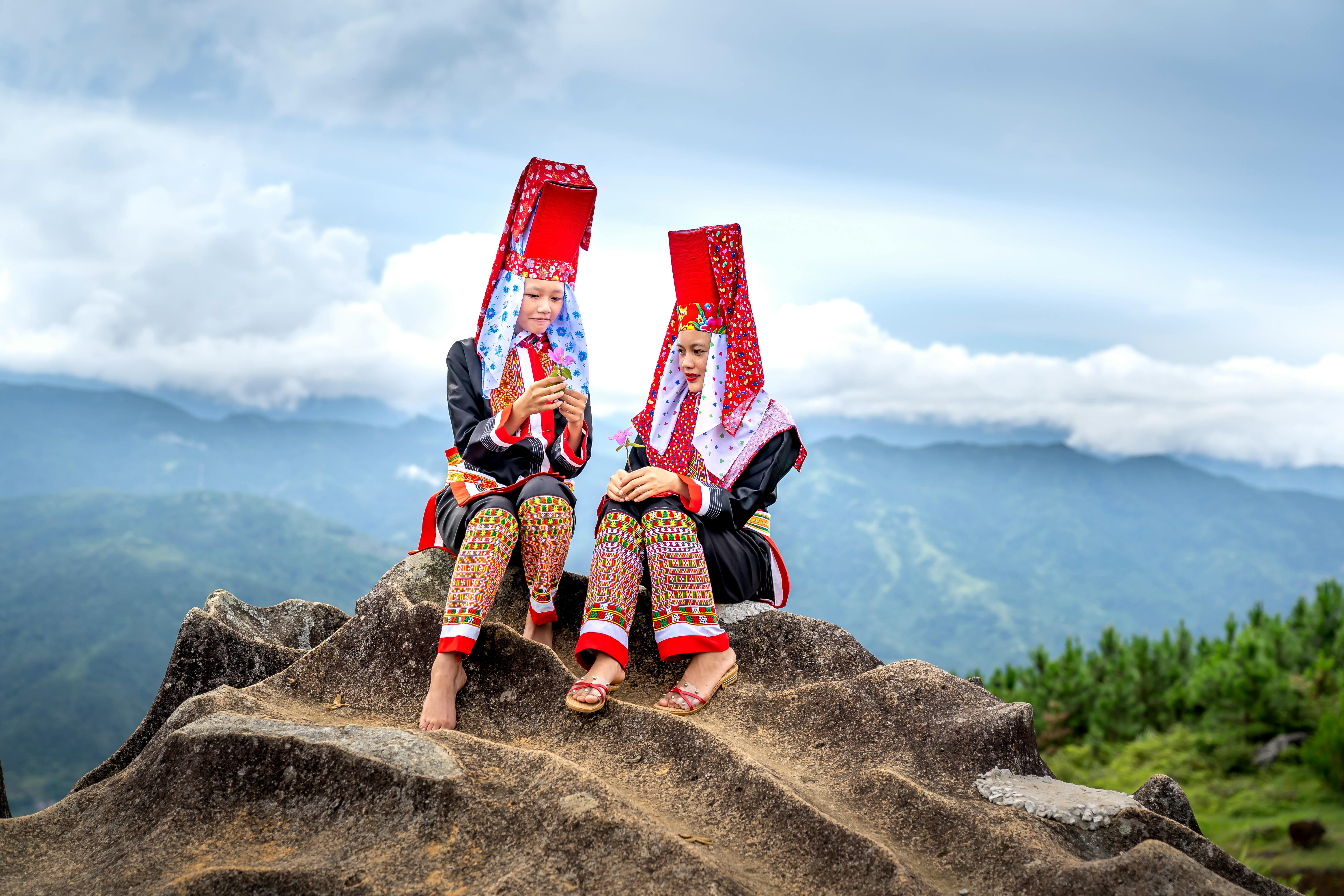Women in Traditional Clothing Sitting in Mountains · Free Stock Photo