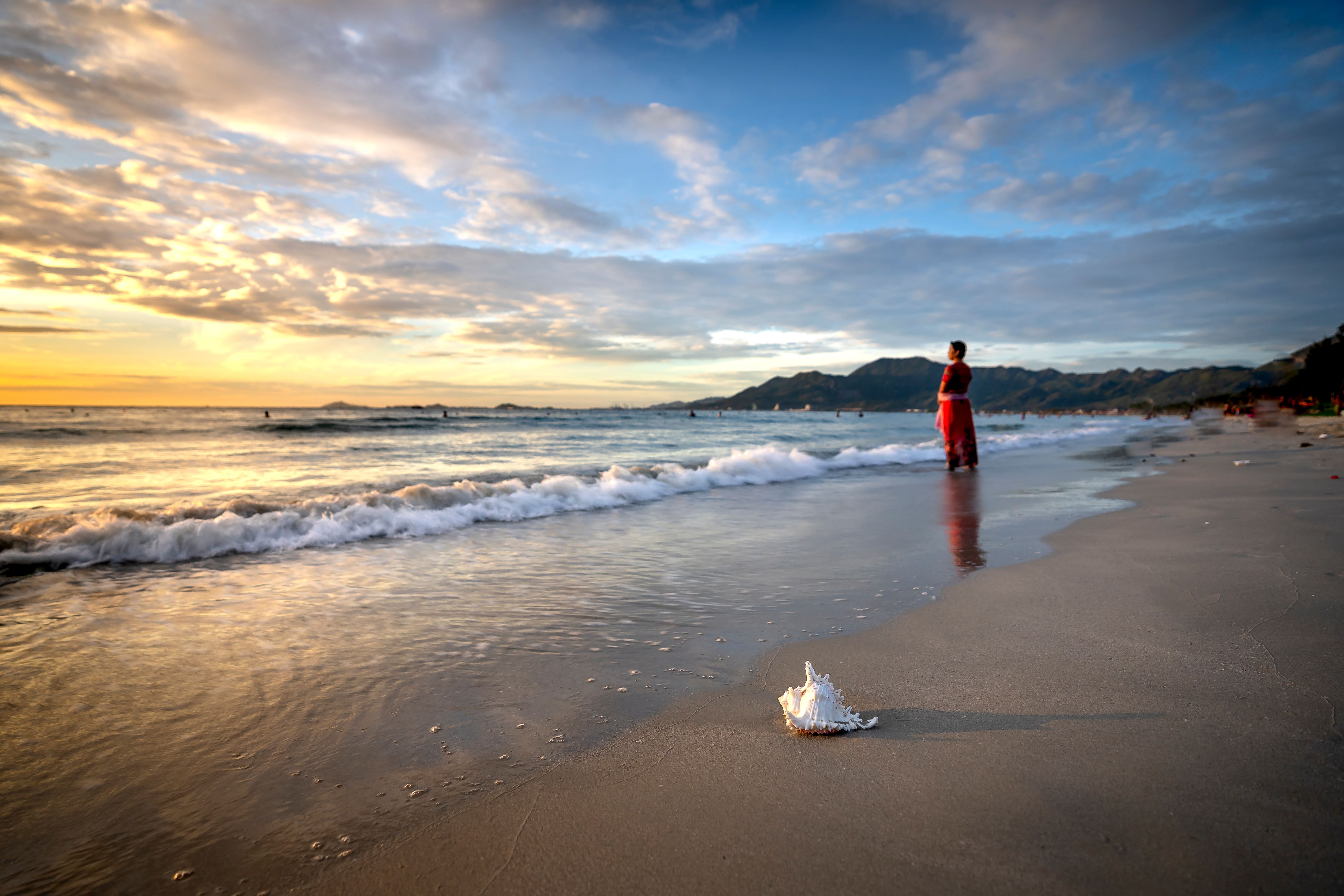 Woman Standing on the Beach at Sunset · Free Stock Photo