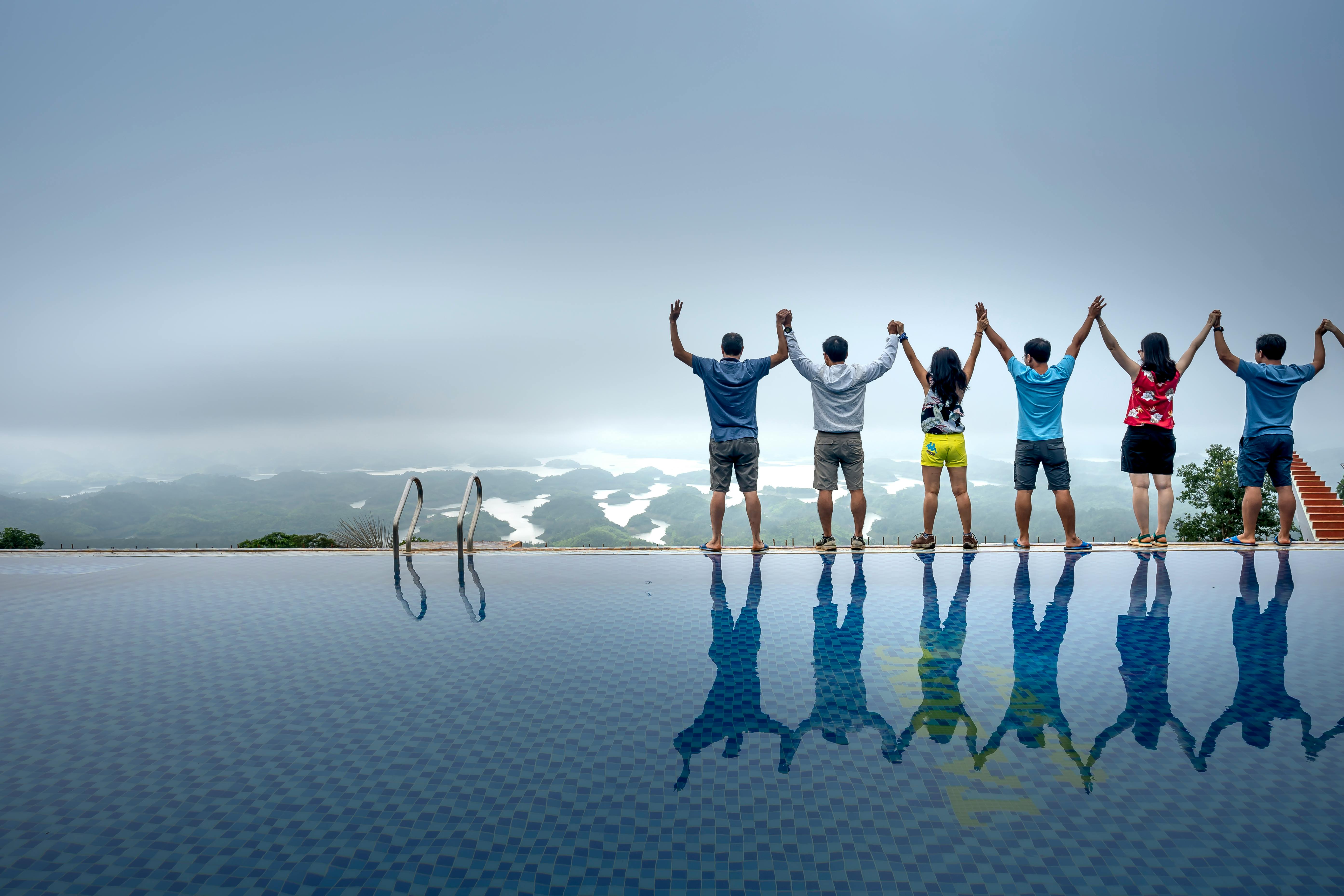 People Standing Hand in Hand by the Swimming Pool · Free Stock Photo