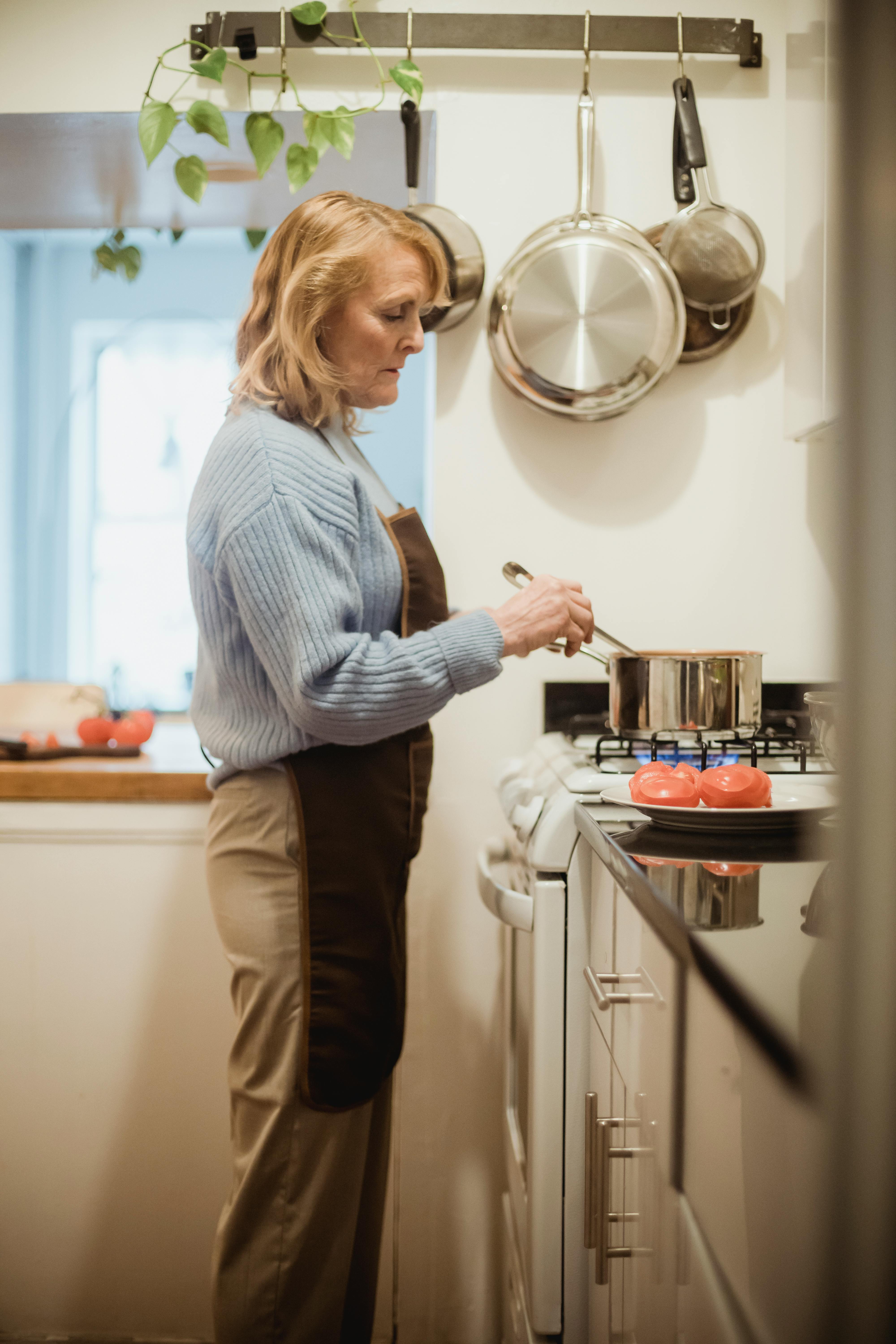 Woman Cooking at the Stove · Free Stock Photo