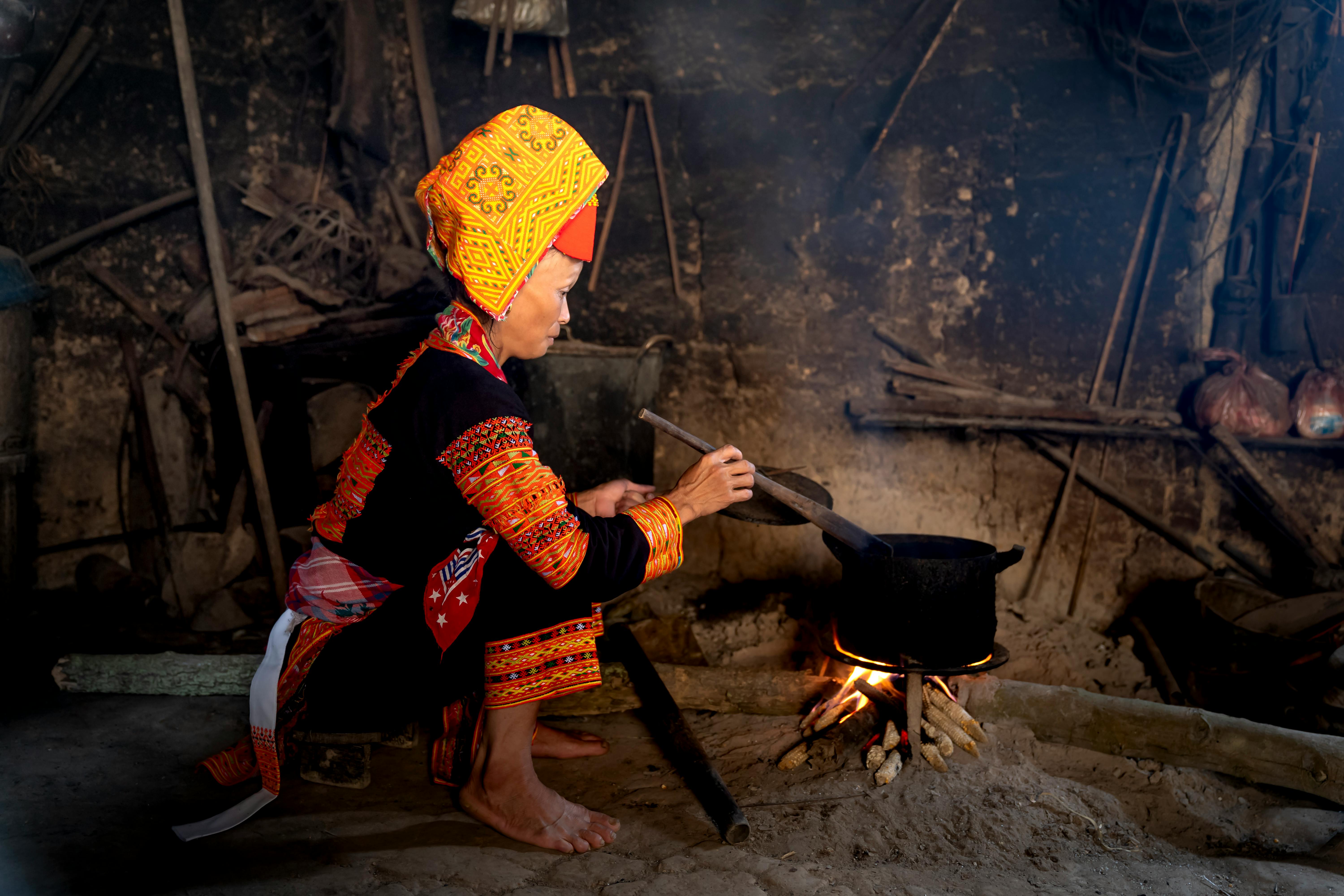 Photo of a Woman in Traditional Clothes Cooking in a Black Pot · Free ...