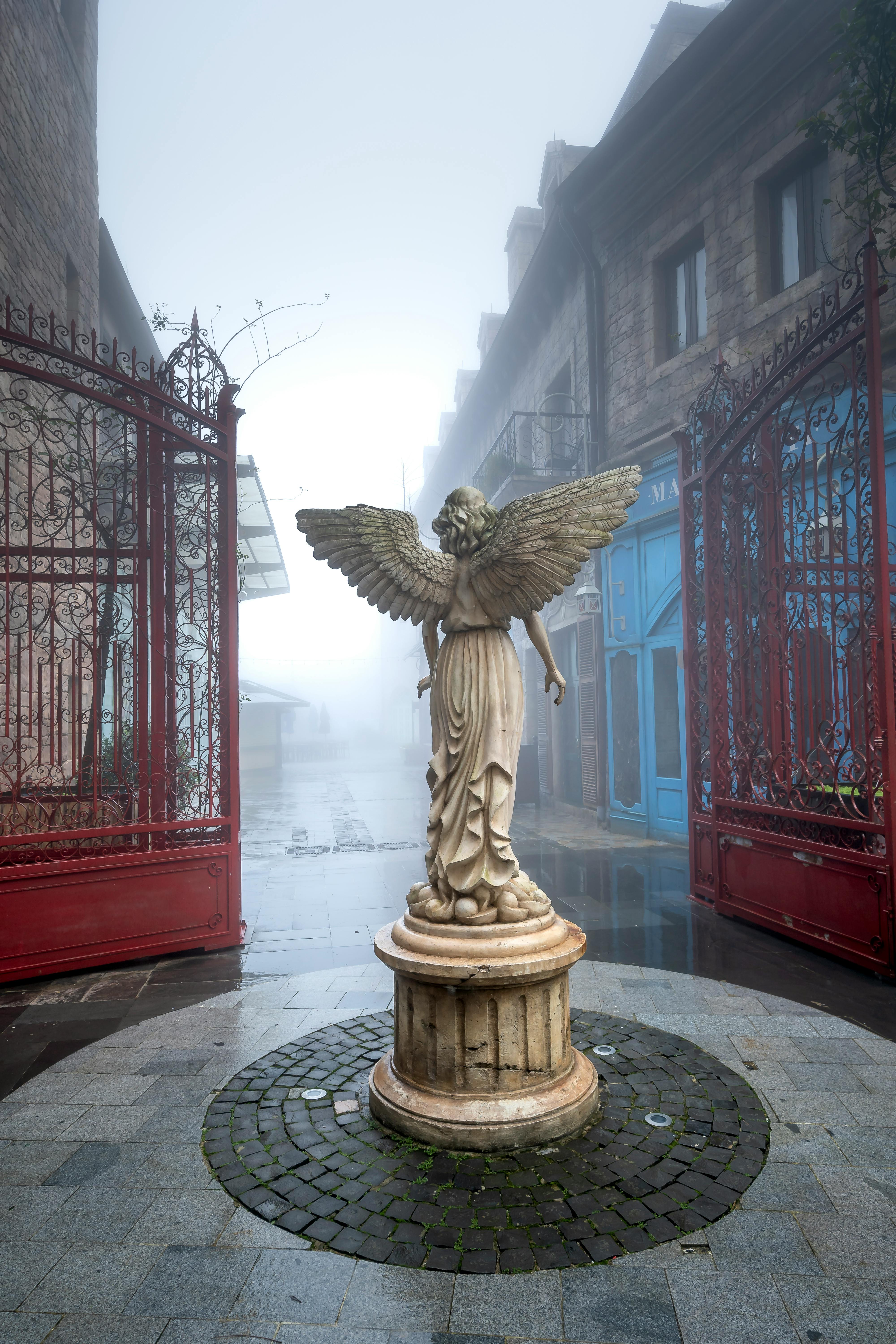 Angle Statue and Open Red Gate · Free Stock Photo