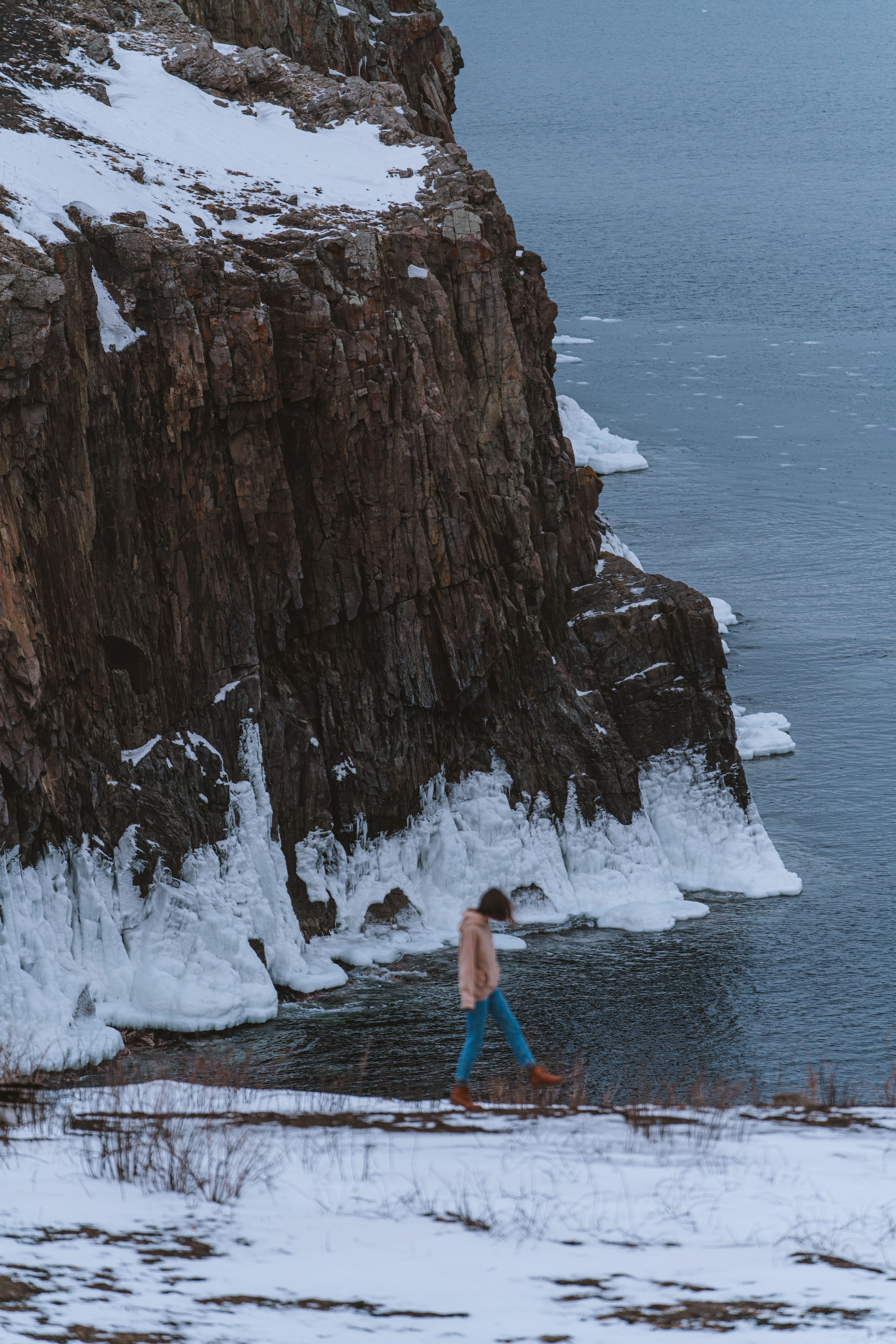 An Aerial Photography of a Person Walking on a Snow Covered Ground Near ...