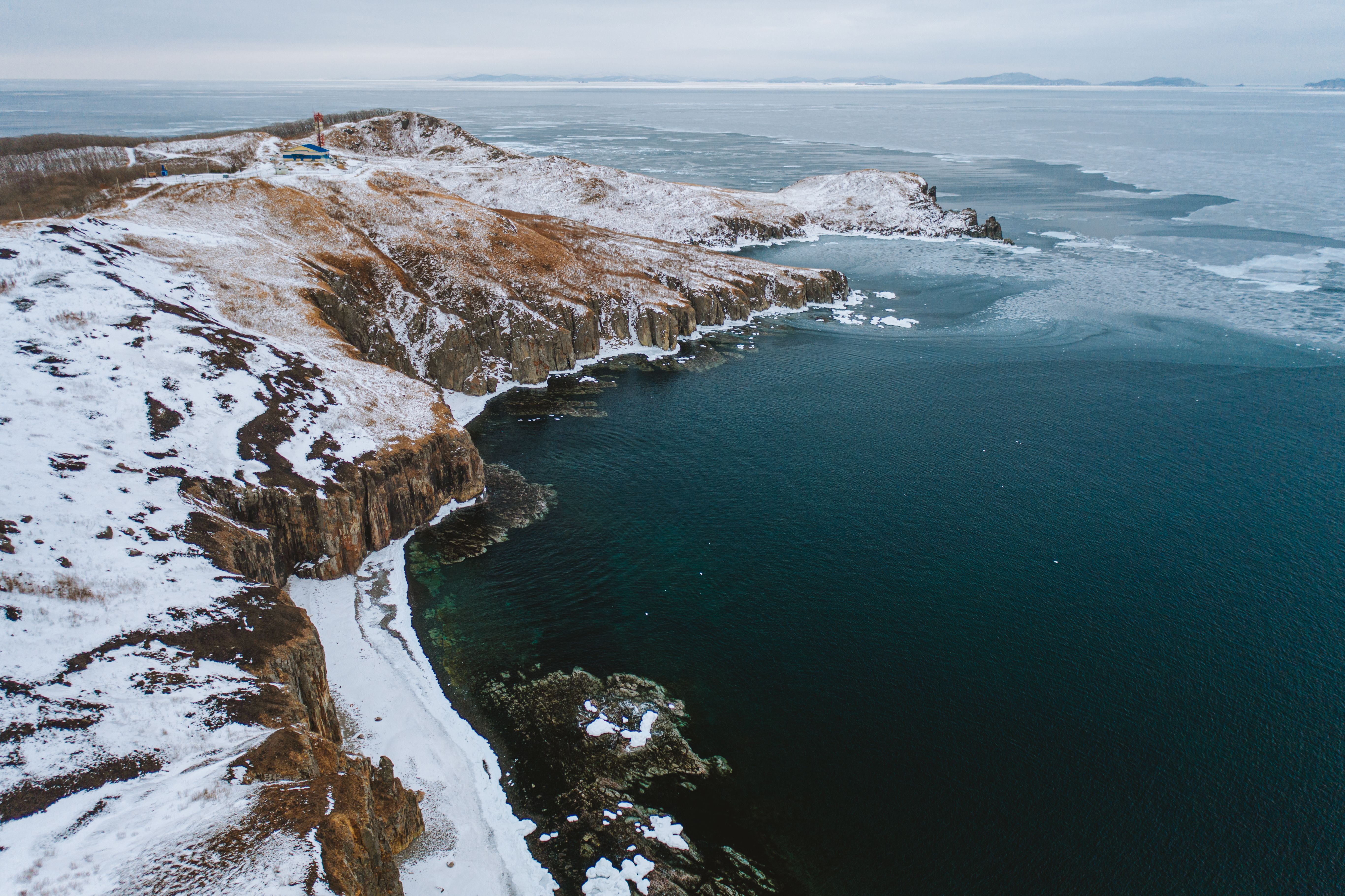 Aerial View of Snow Covered Mountain Beside Body of Water · Free Stock ...