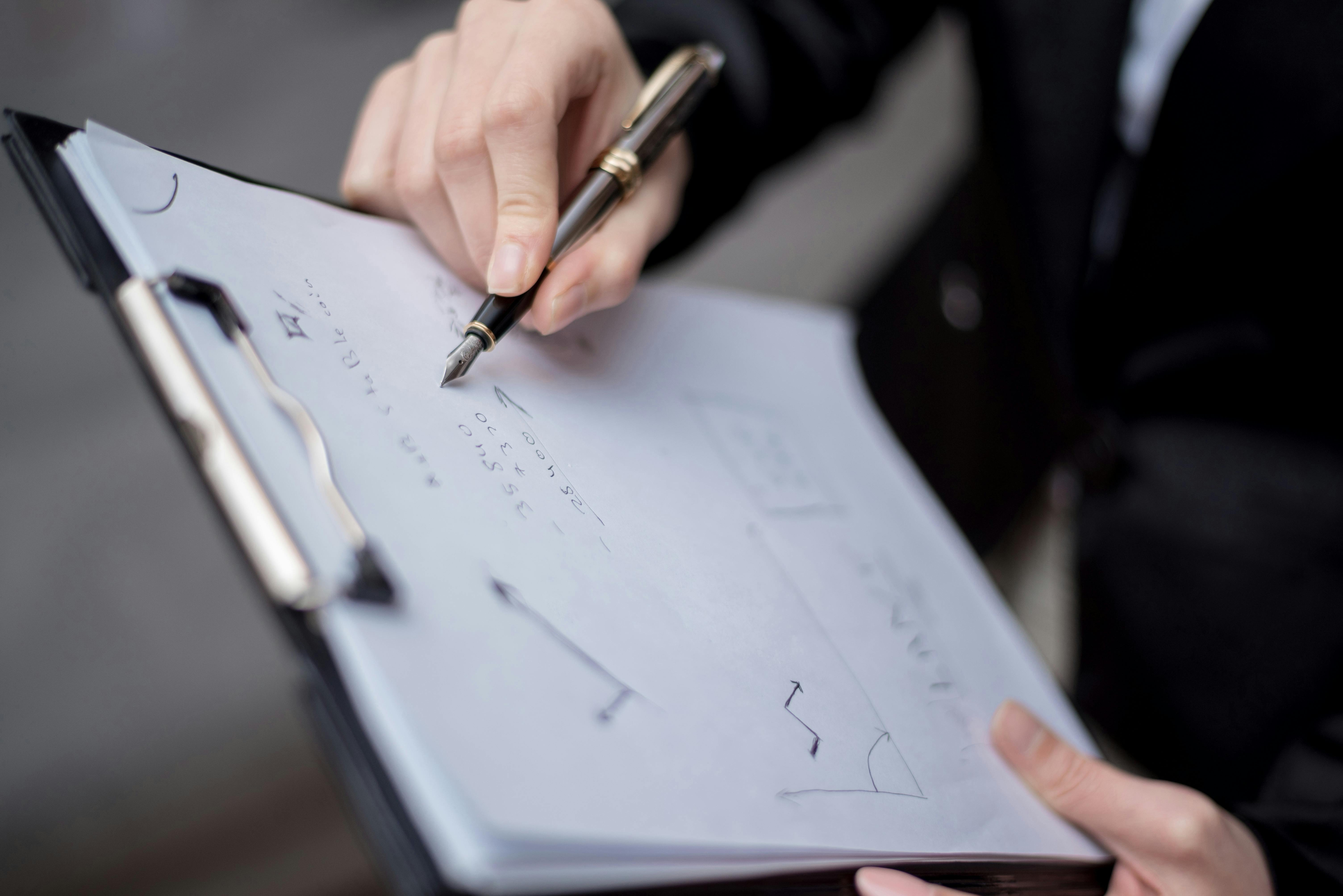 Close-Up Shot of a Person Writing on a Paper Using a Pen · Free Stock Photo