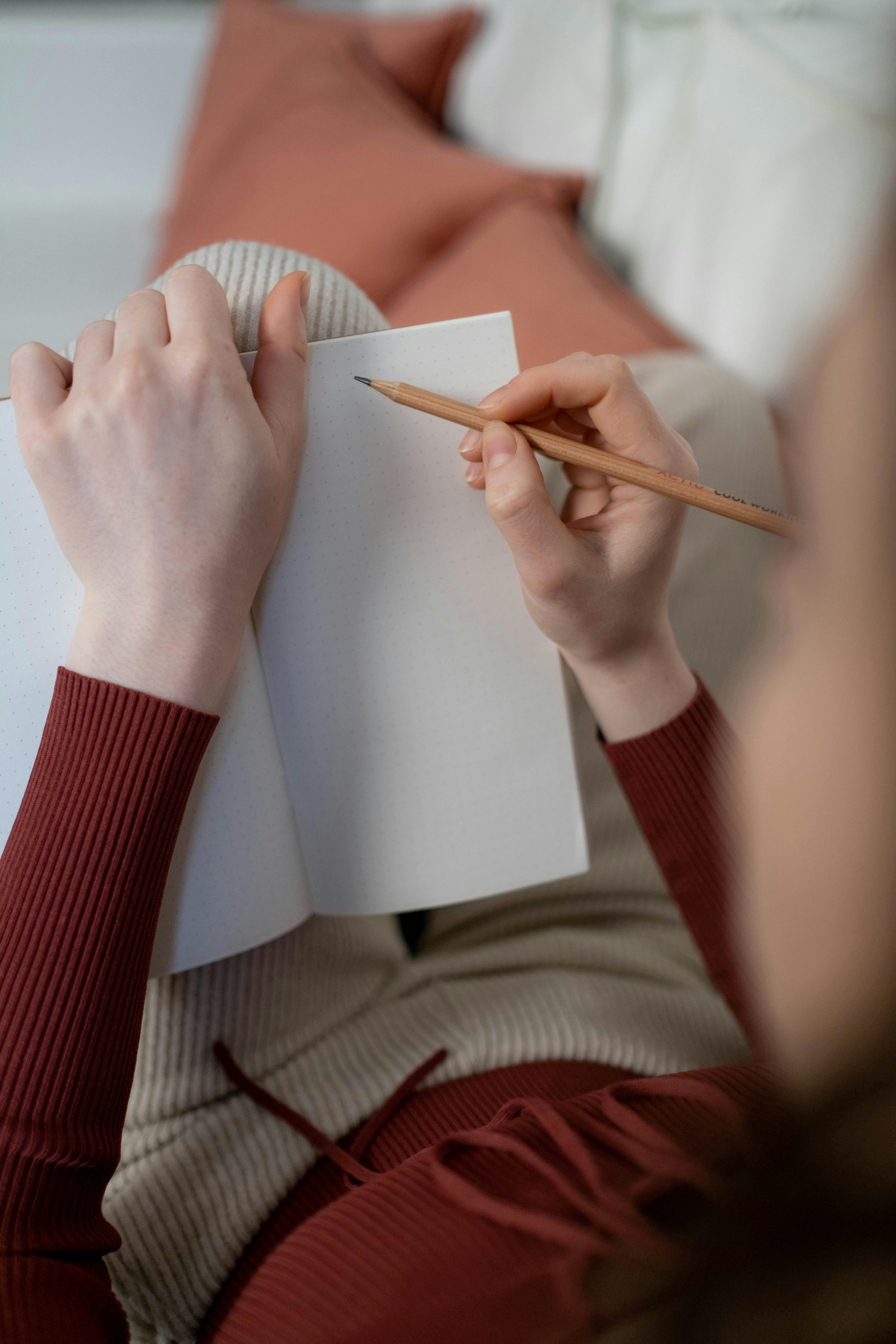 A Person Holding a Pencil and a Notebook · Free Stock Photo