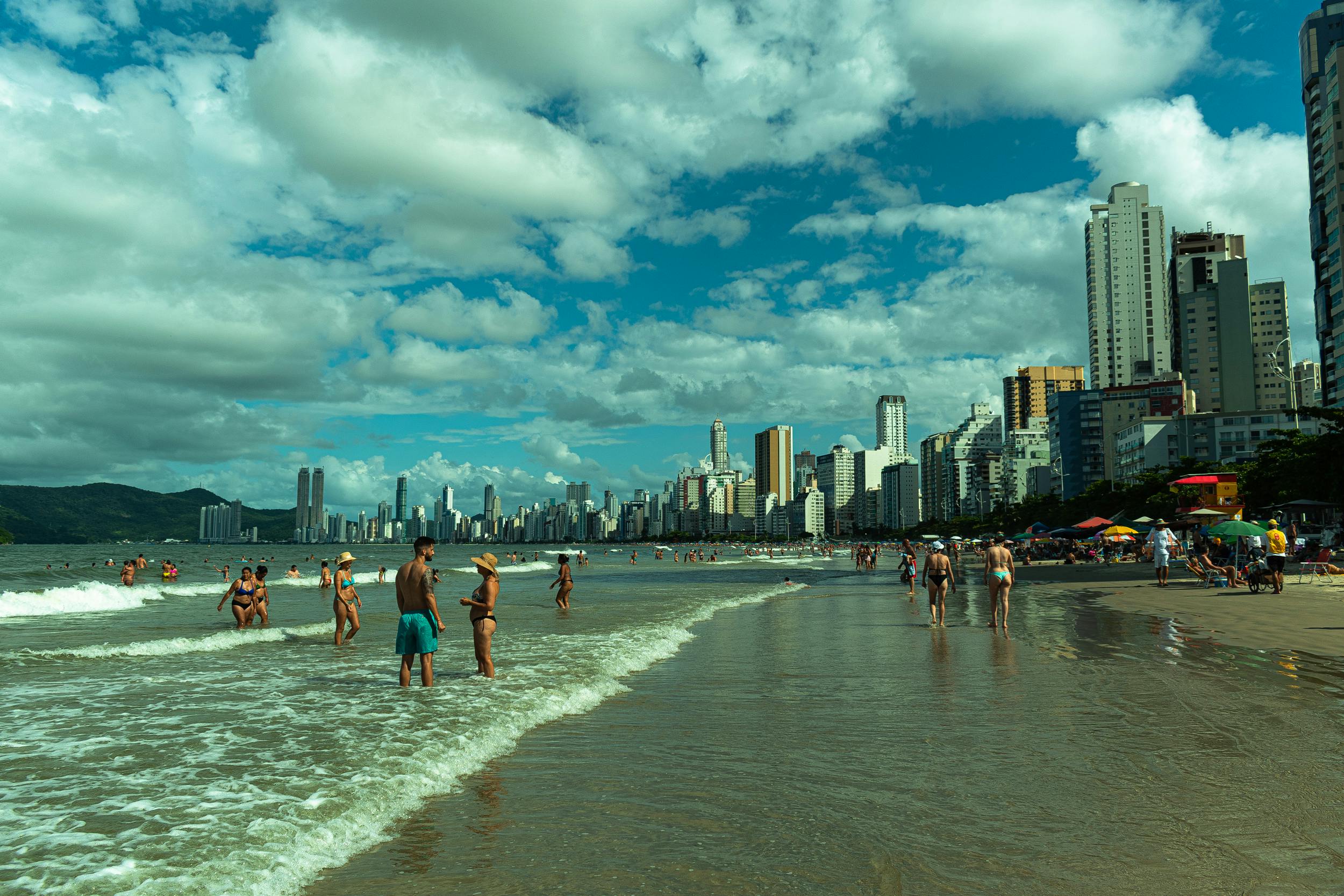 People at the Beach near City Buildings · Free Stock Photo