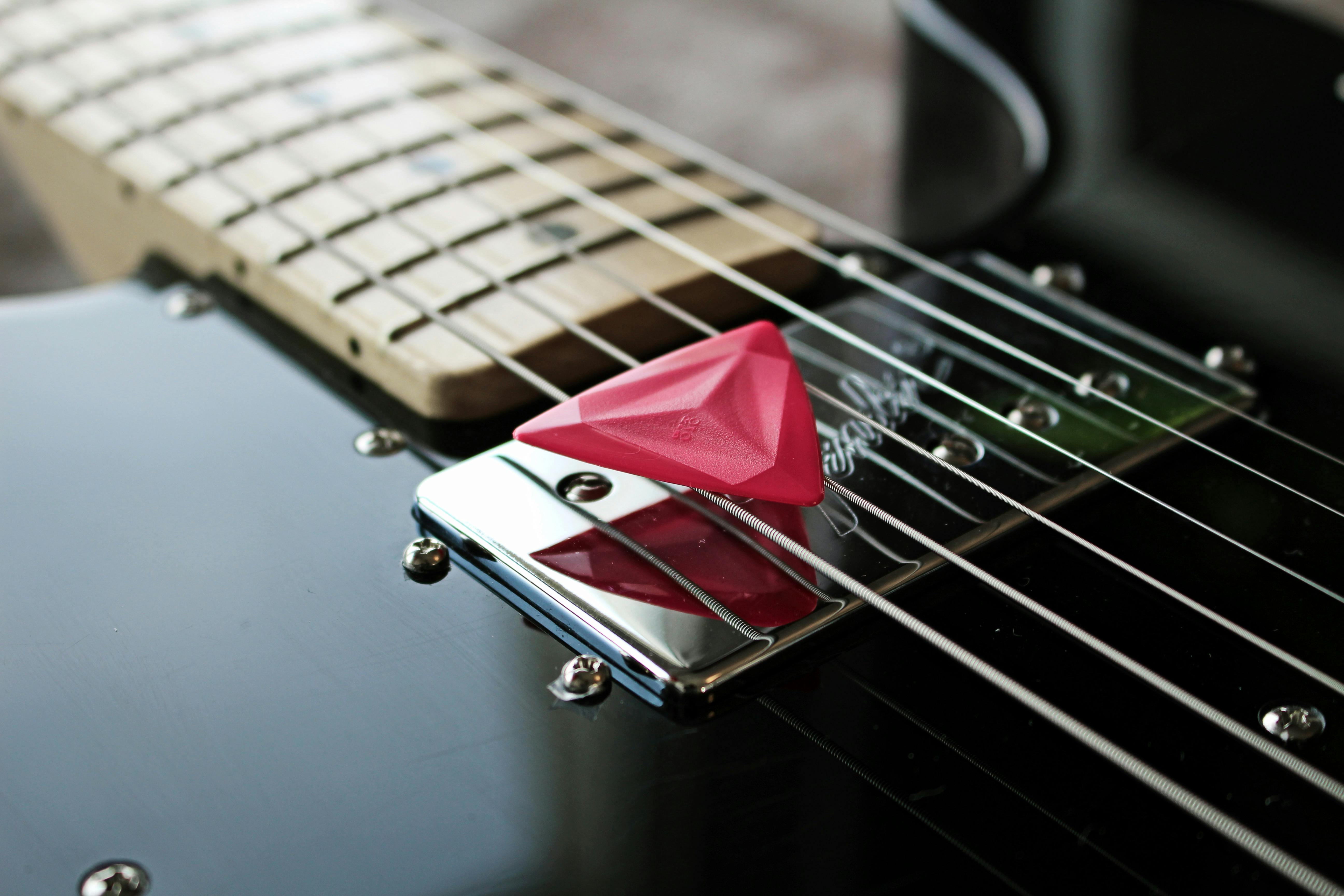 Red Guitar Pick on a Guitar · Free Stock Photo