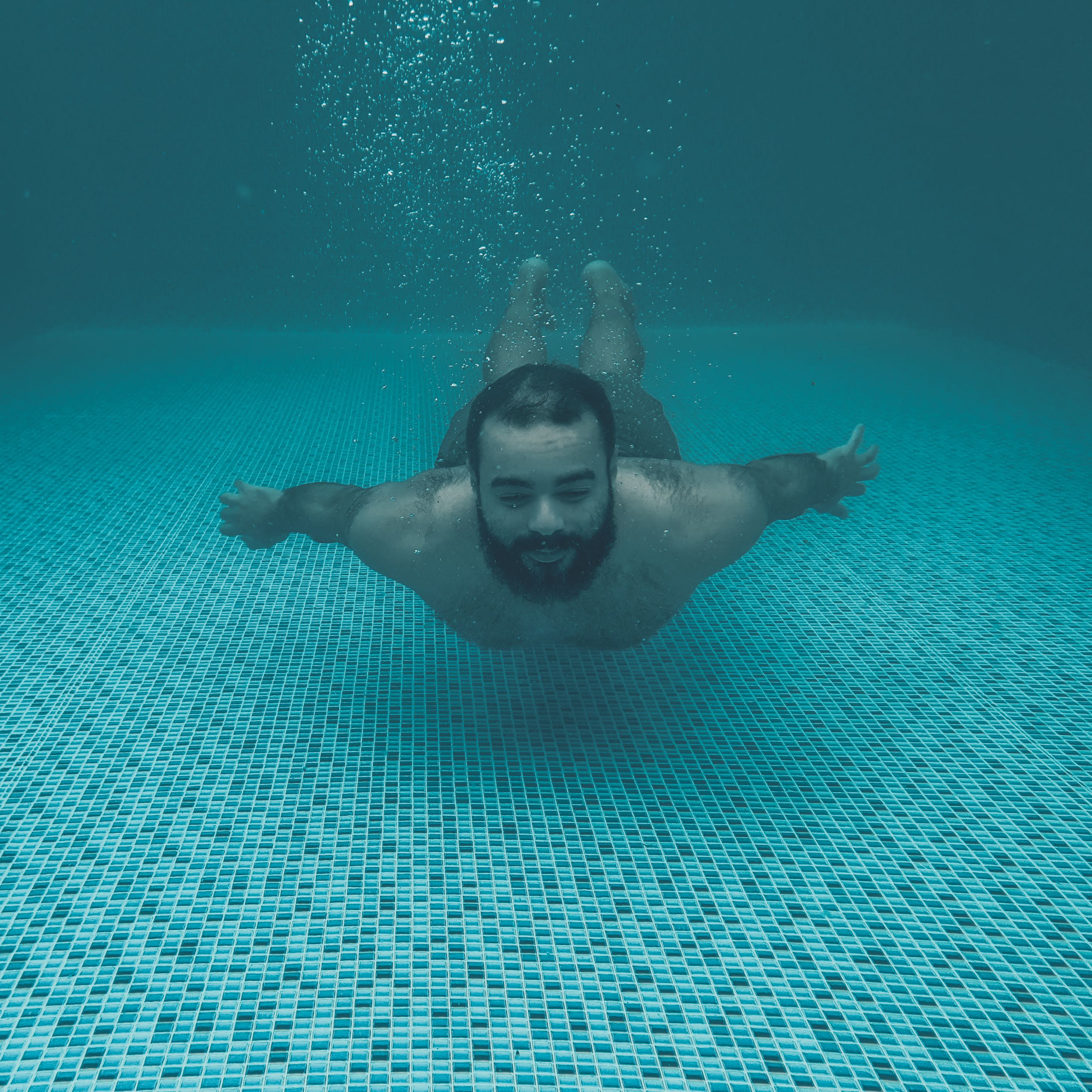 A Bearded Man Swimming Underwater in a Pool · Free Stock Photo