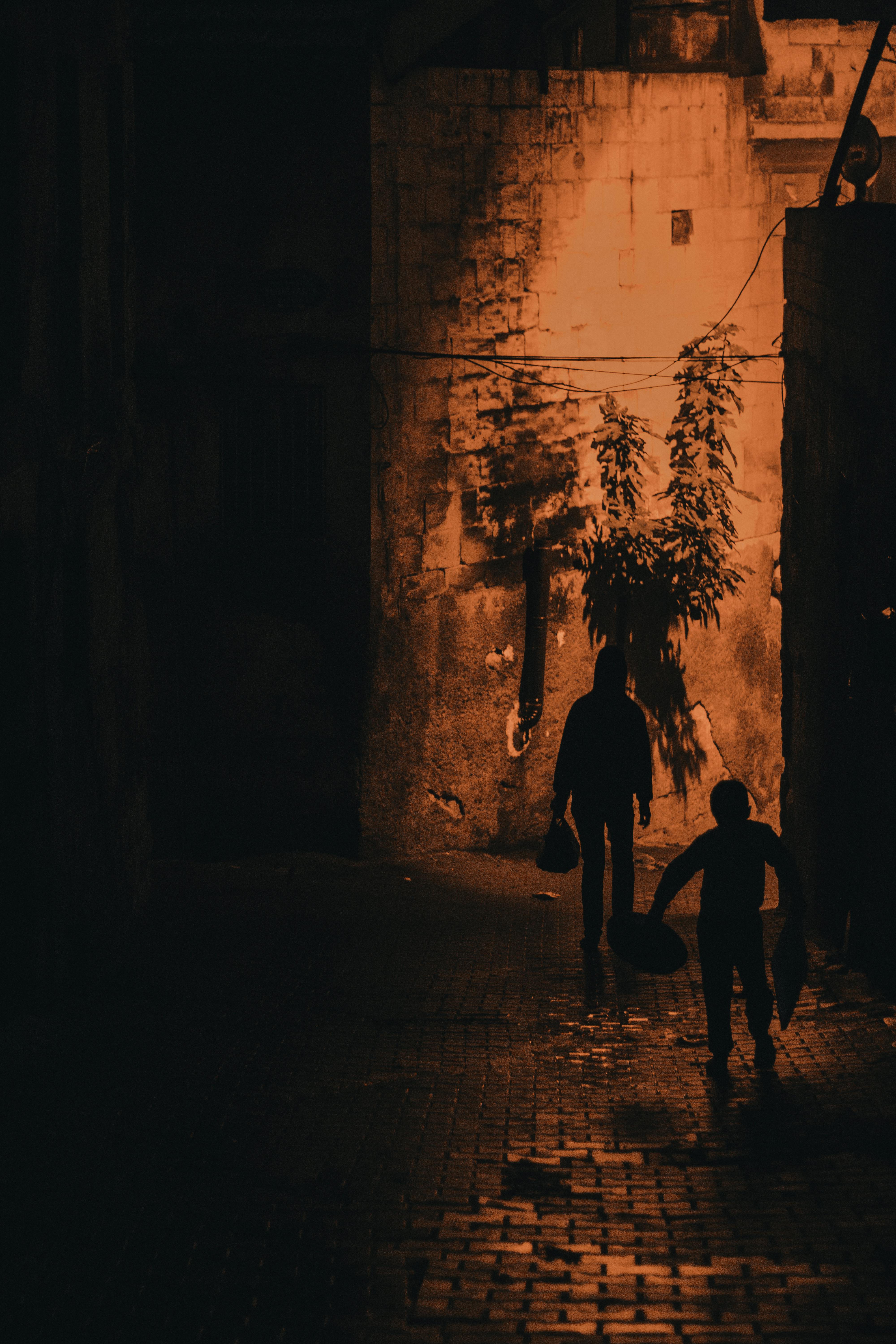 Silhouette of People Walking on a Dark Pavement · Free Stock Photo