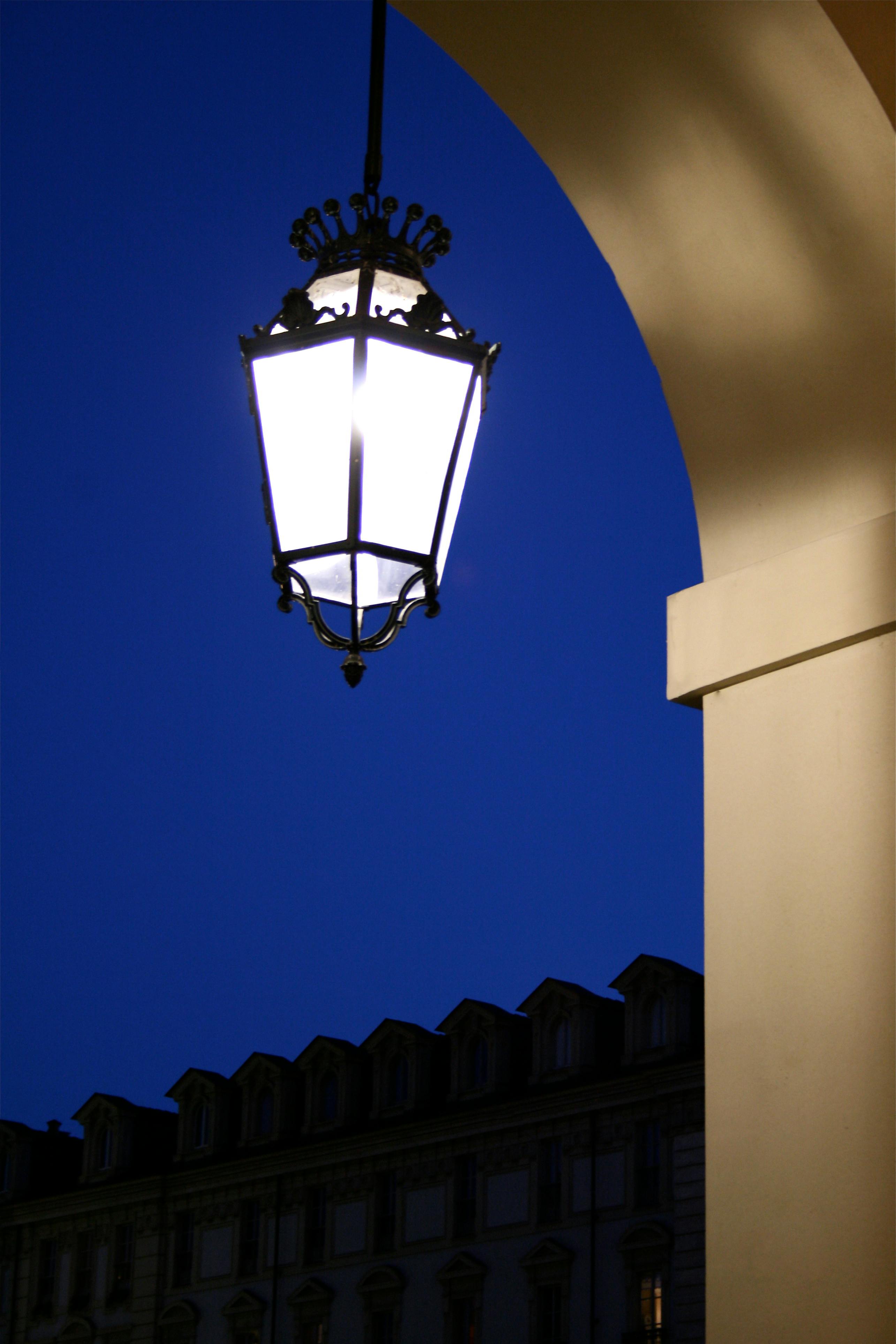 A Lighted Lamppost Hanging from an Arched Opening · Free Stock Photo