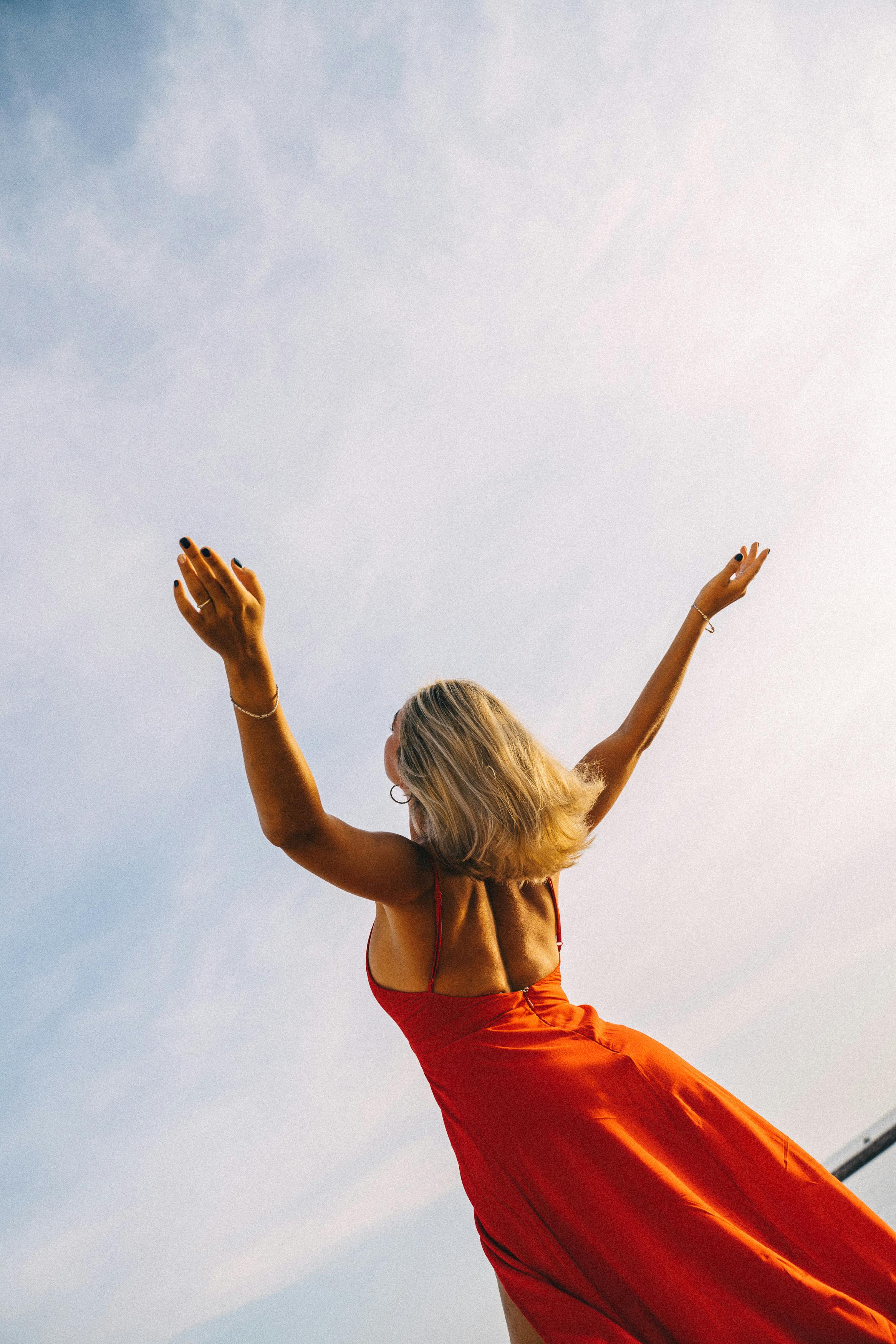 Woman in White Shirt and Denim Shorts Raising Her Arms · Free Stock Photo
