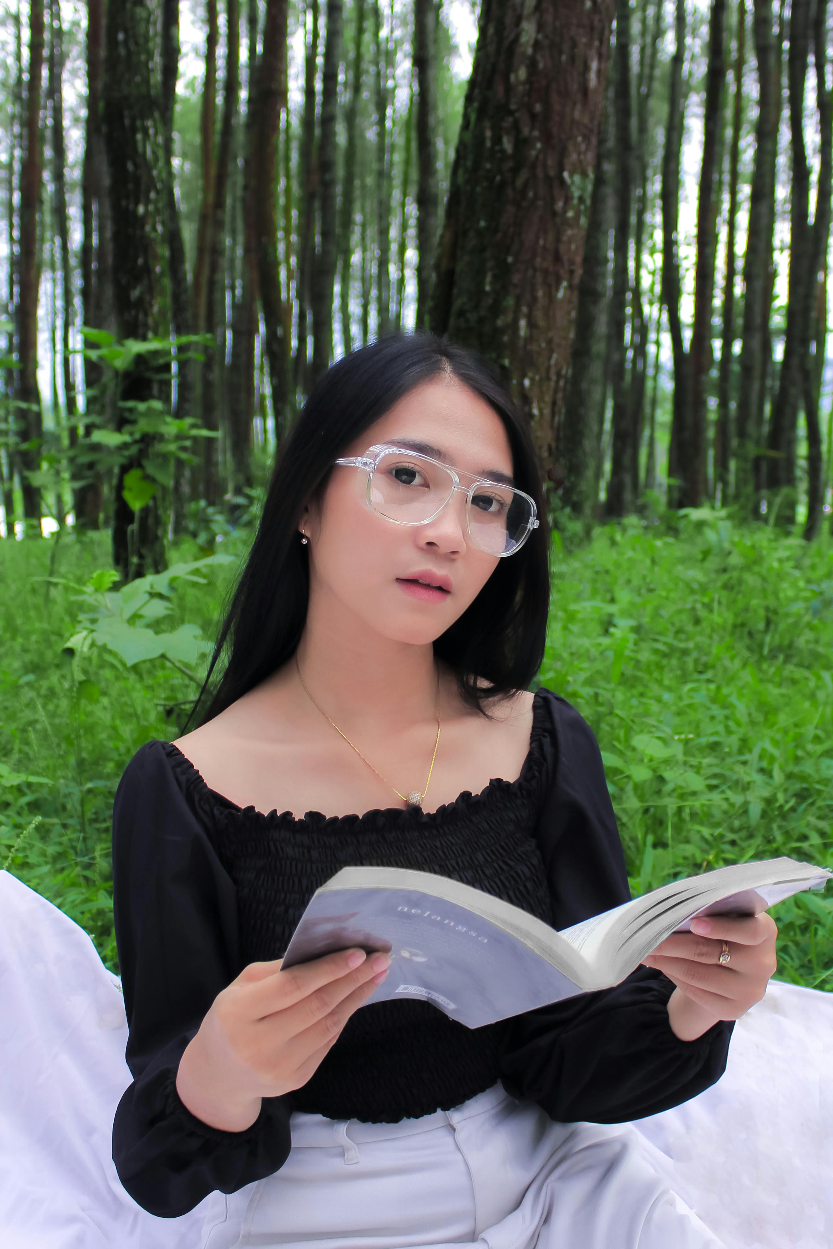 Woman Redaing a Book on a Forest Field · Free Stock Photo