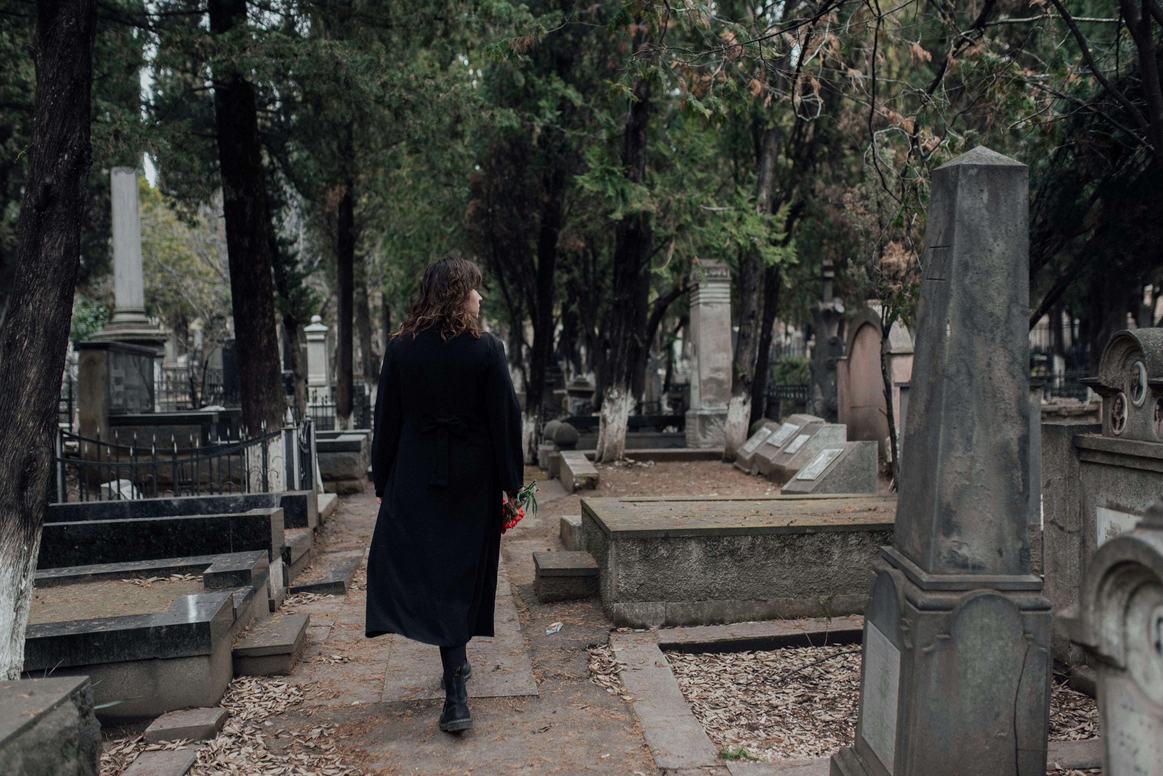 Woman in Black Dress Walking in a Cemetery · Free Stock Photo
