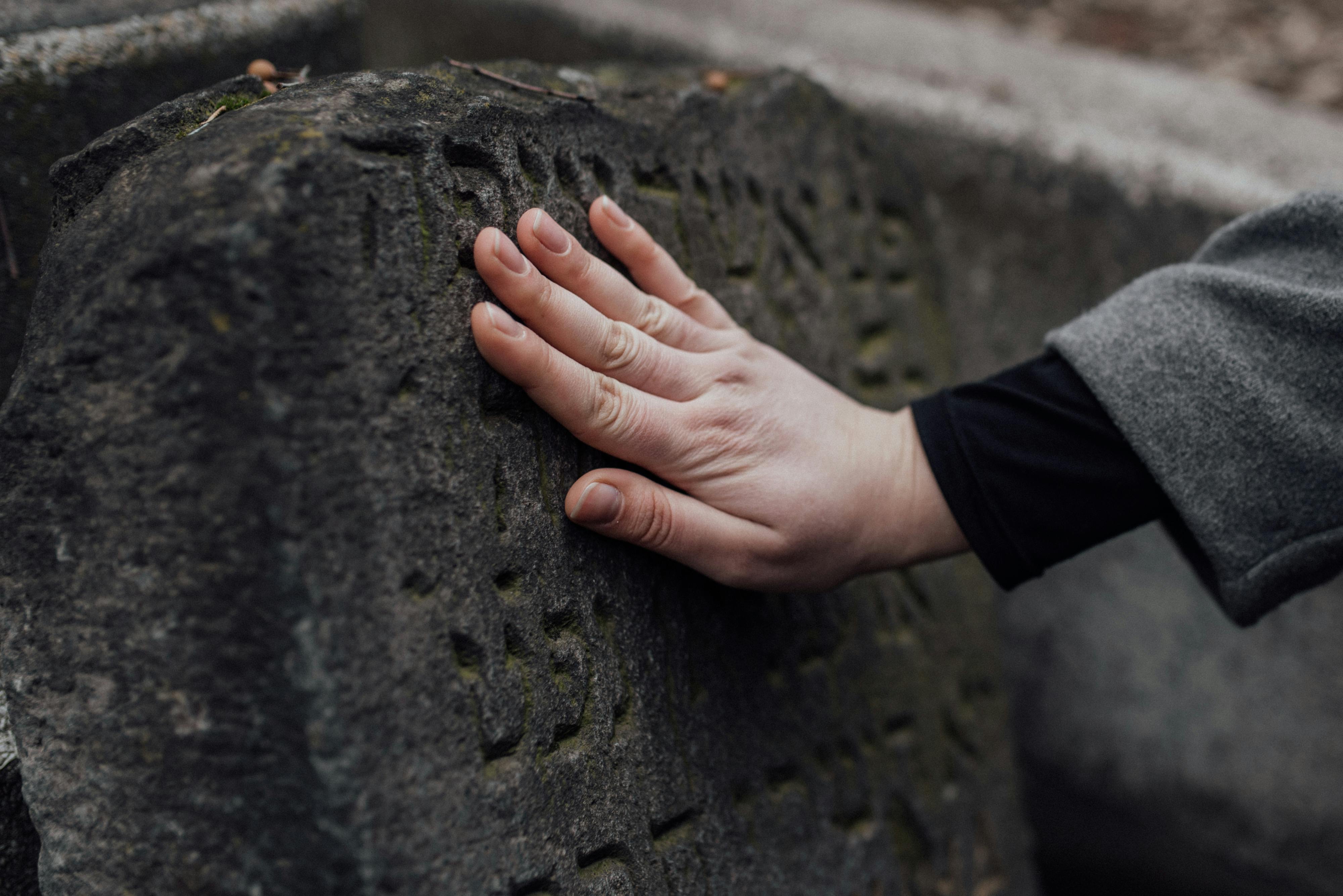 A Person Touching a Stone with Carvings · Free Stock Photo