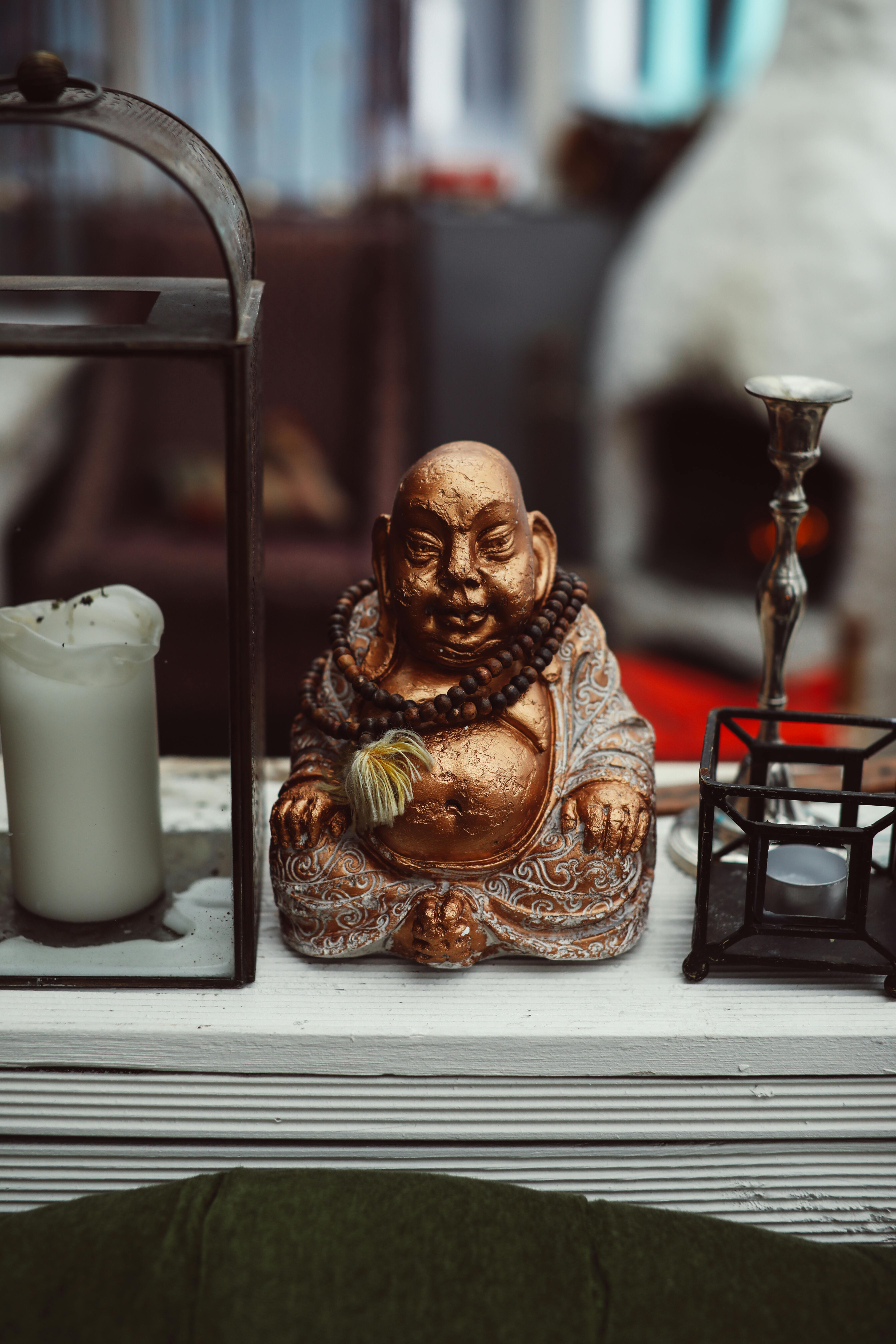 Buddha Figurine On Display Beside A Candle · Free Stock Photo