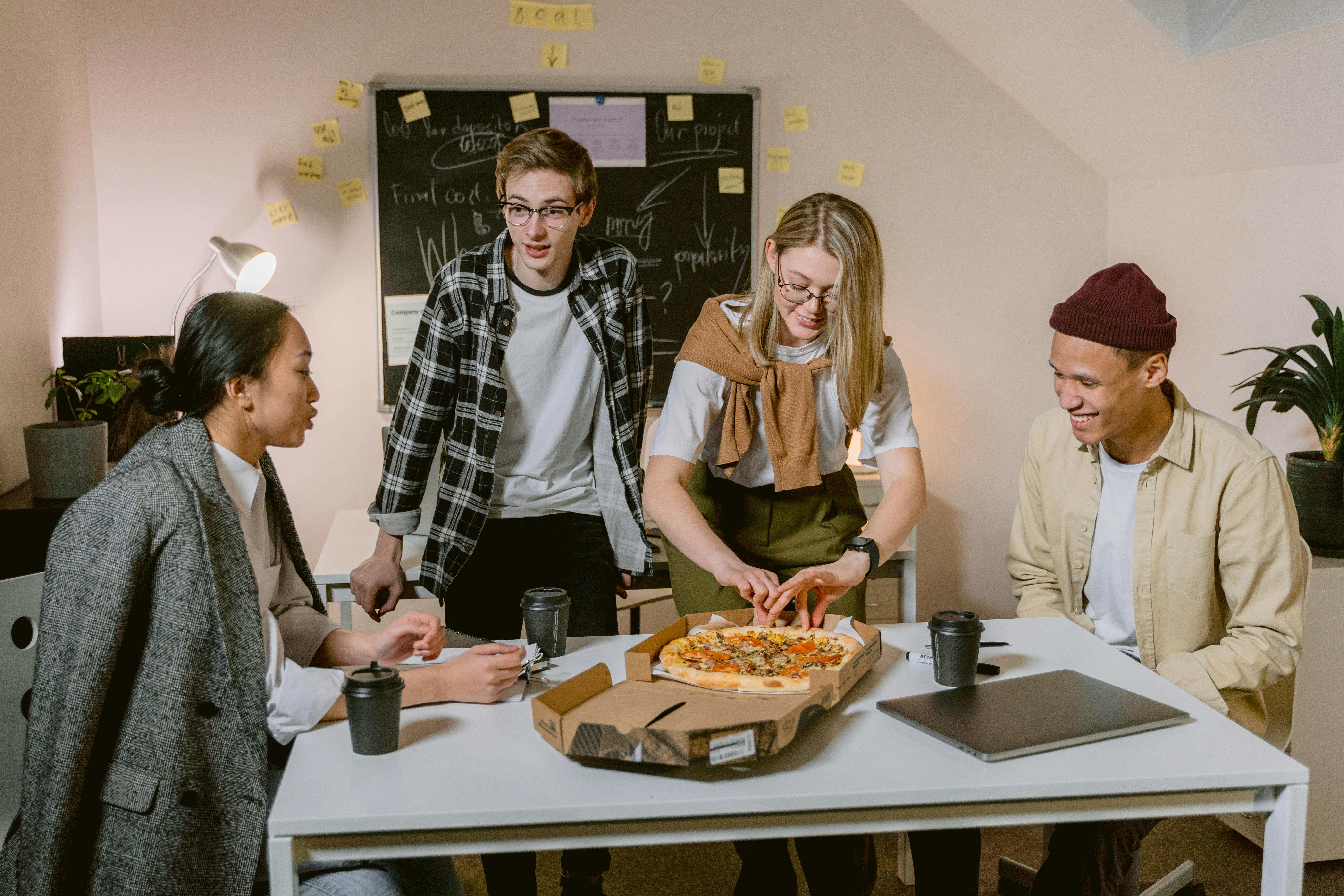 Coworkers Having Pizza for Lunch at an Office · Free Stock Photo