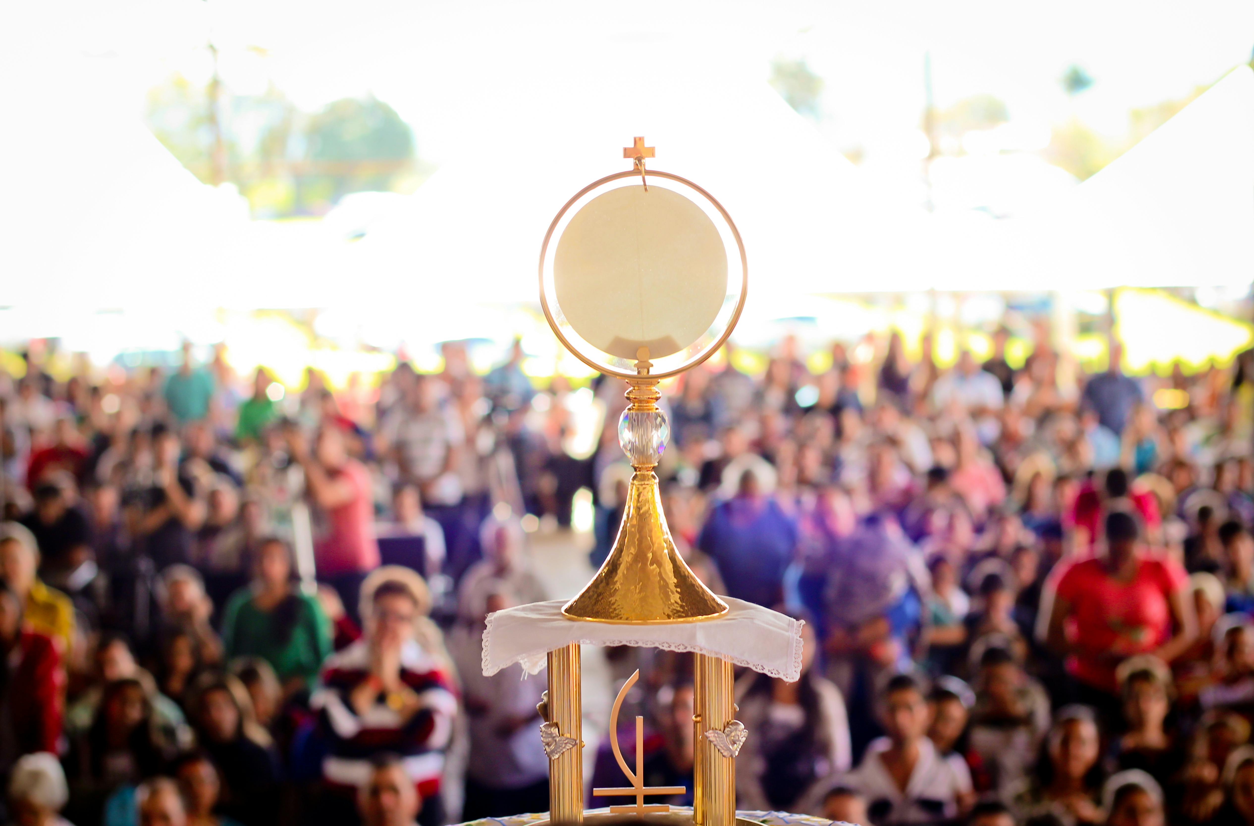 Golden monstrance against blurred church interior · Free Stock Photo