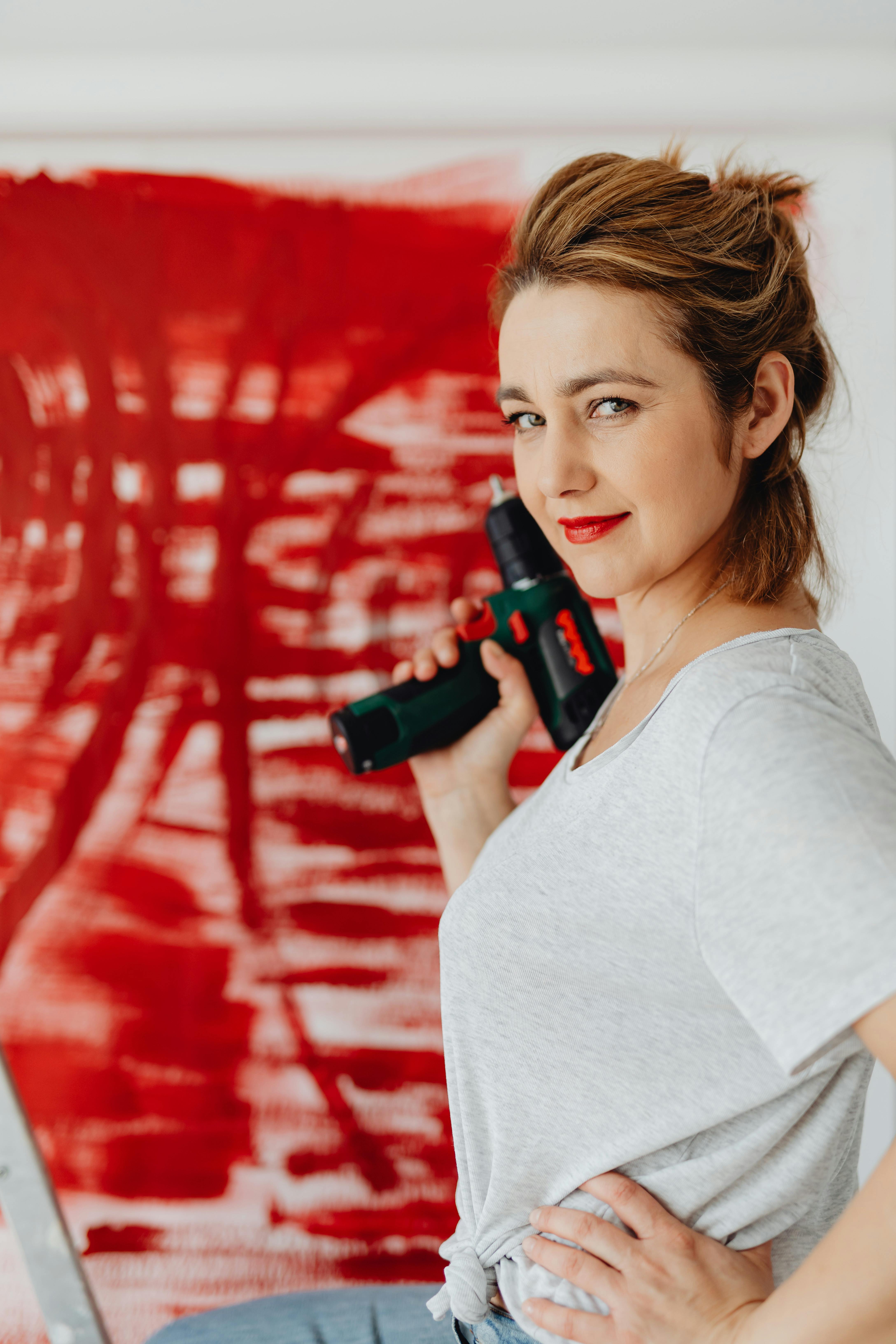 Woman in Gray Shirt Holding a Hand Drill · Free Stock Photo