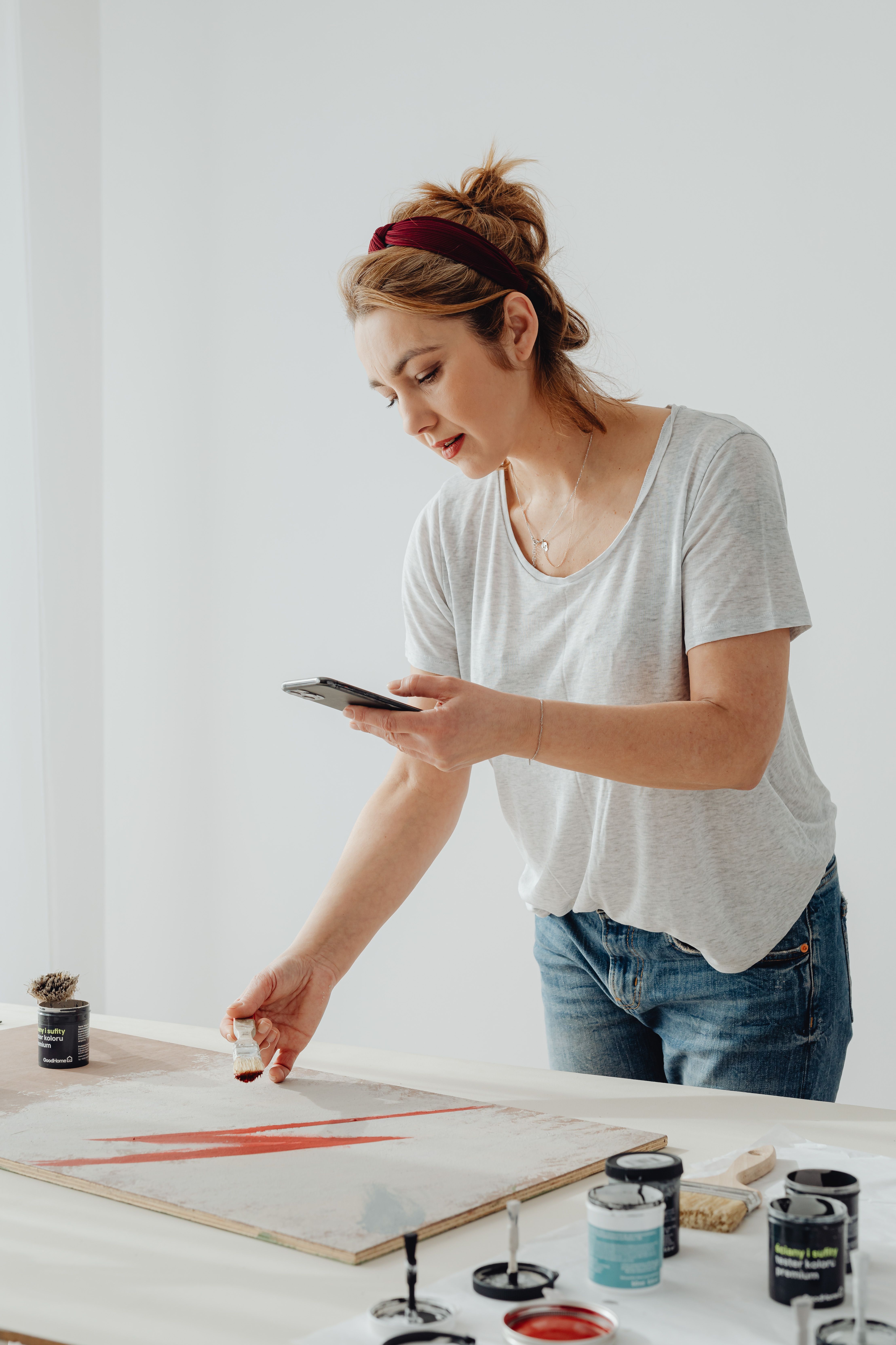 Photo of a Woman Painting while Looking at Her Cell Phone · Free Stock ...