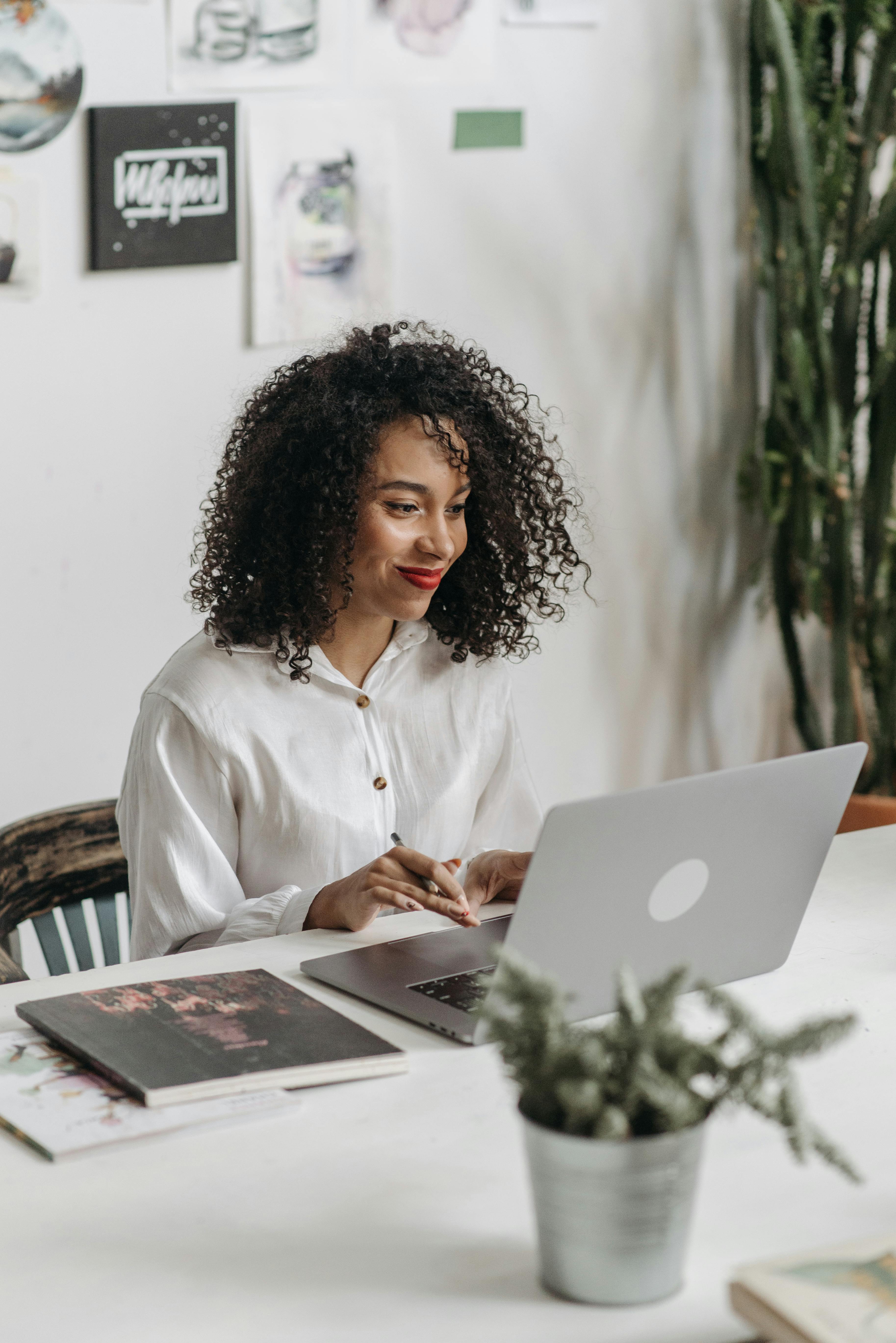 Woman in White Dress Shirt Using a Laptop · Free Stock Photo