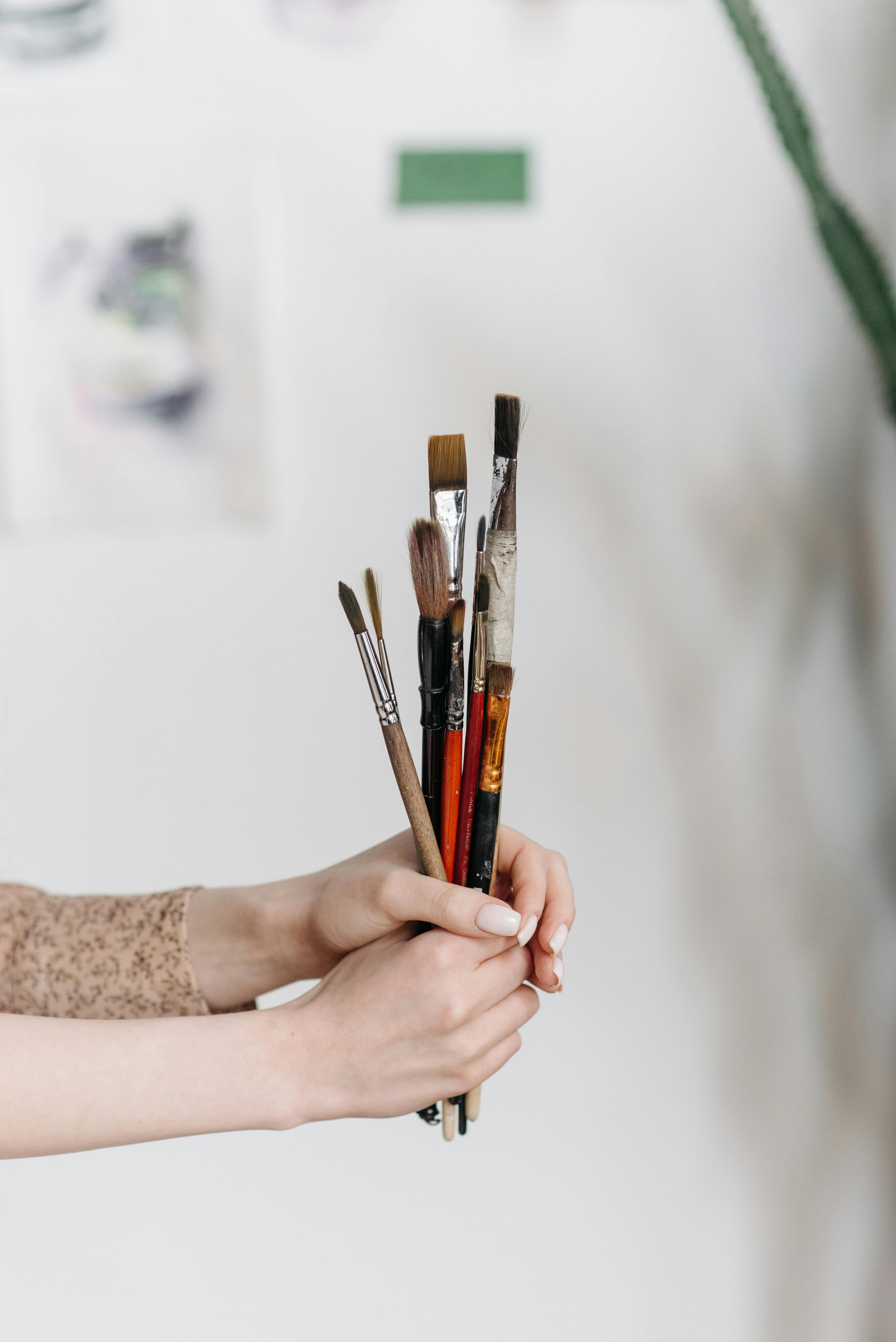 Person Holding Paint Brushes · Free Stock Photo